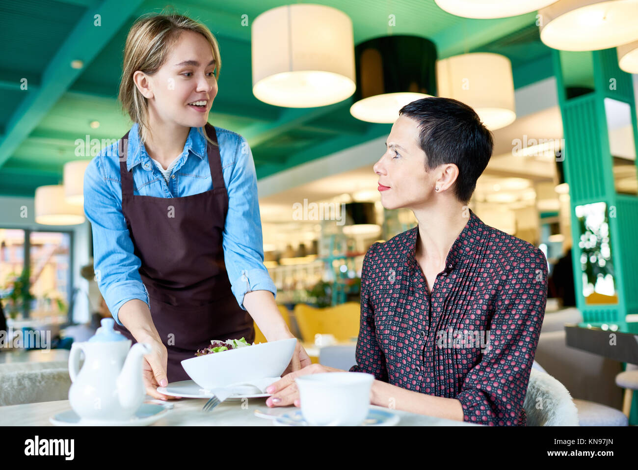 Young Waitress Bringing Food to Female Guest Stock Photo - Alamy