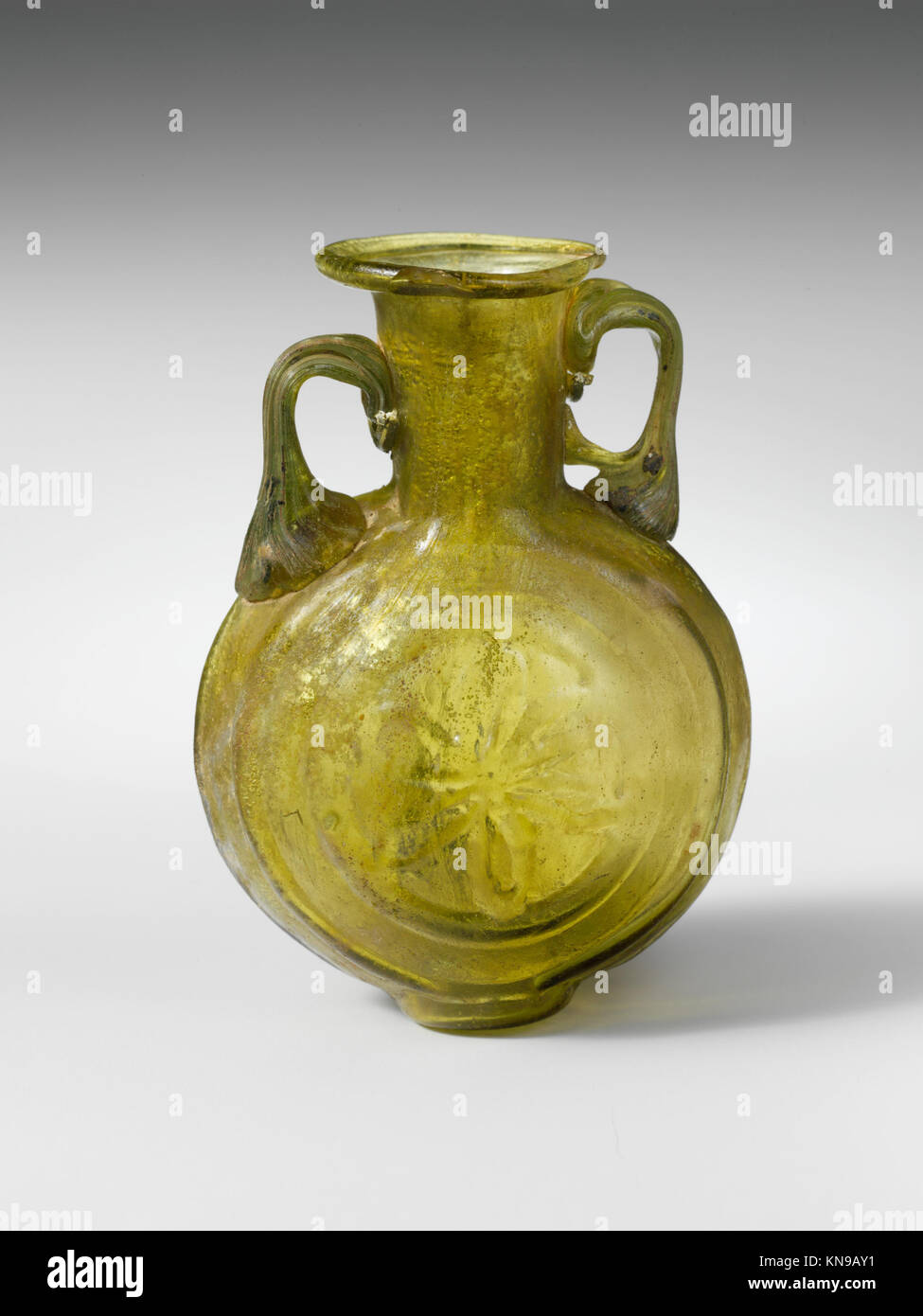 This glass amphoriskos, with a lentoid shape, is a small container from ...