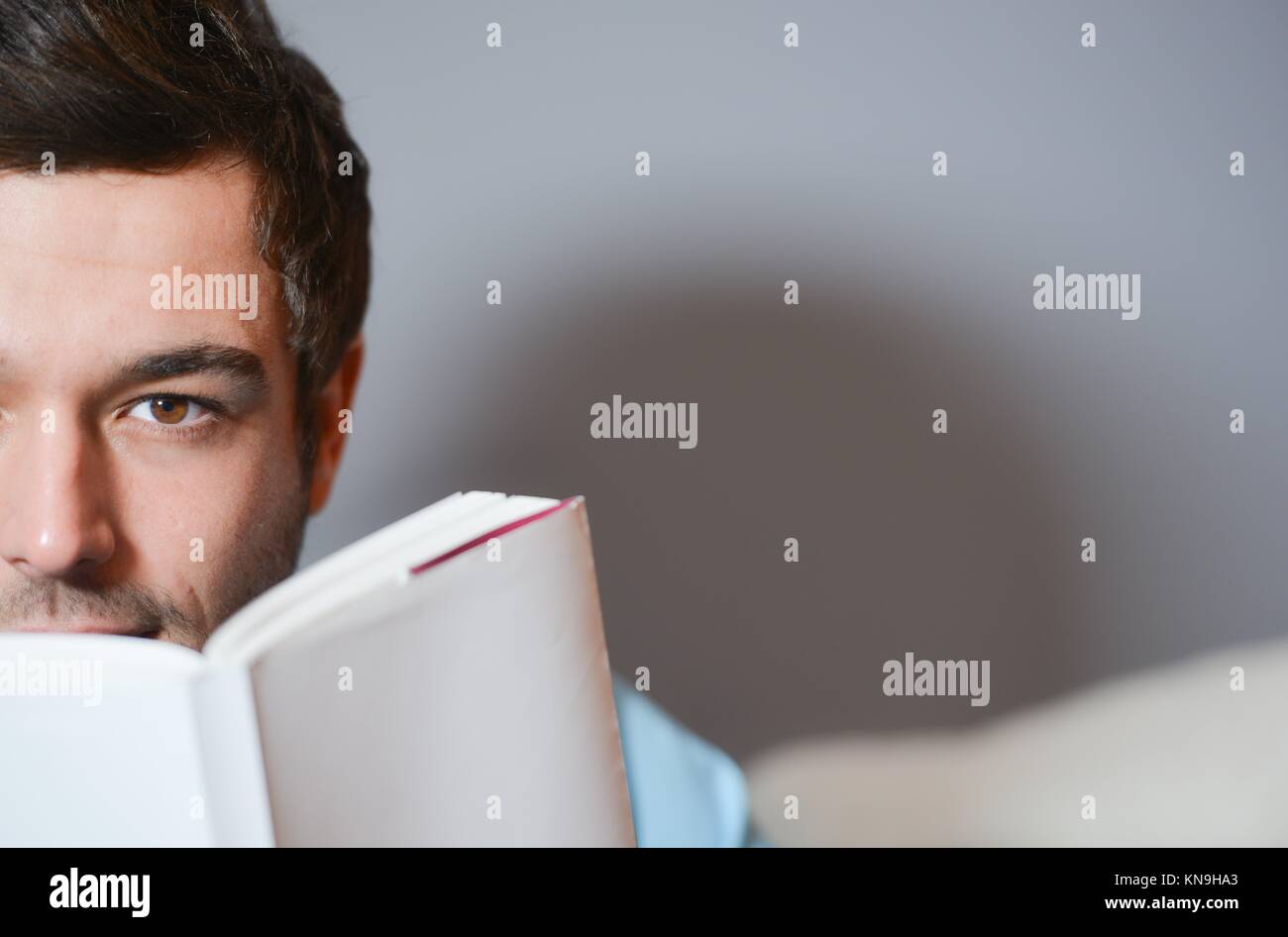 Man at home reading book close up Stock Photo - Alamy