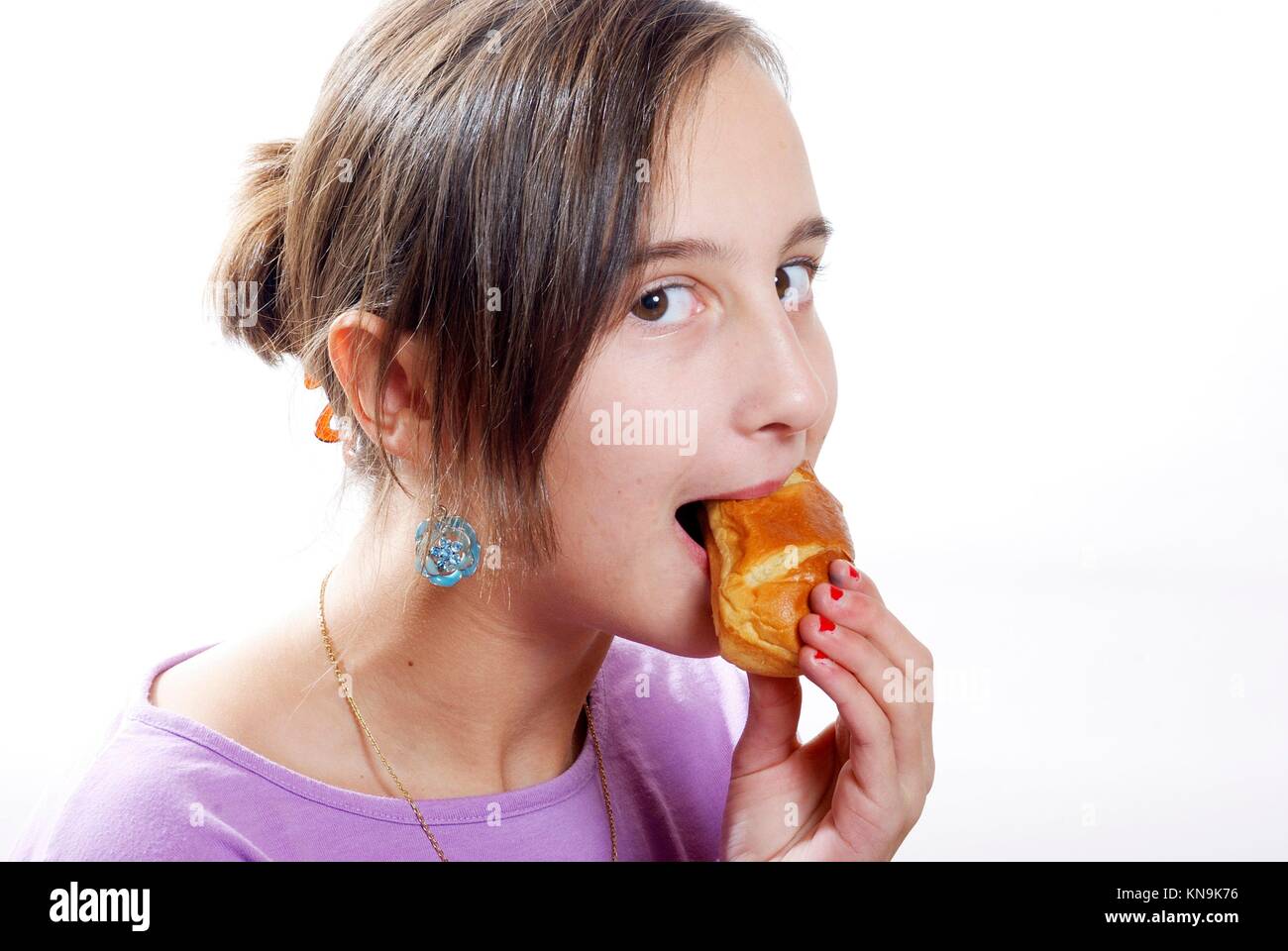 A young girl eating a bun Stock Photo - Alamy