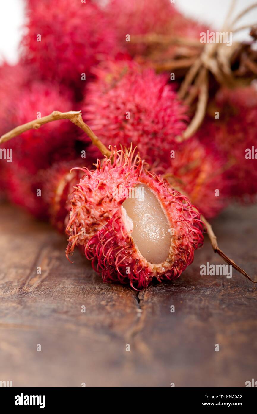 fresh tropical rambutan fruits over rustic wood table Stock Photo - Alamy