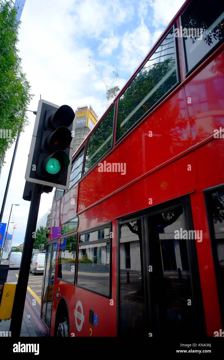 Red London bus moving past green traffic light in London, England, UK ...