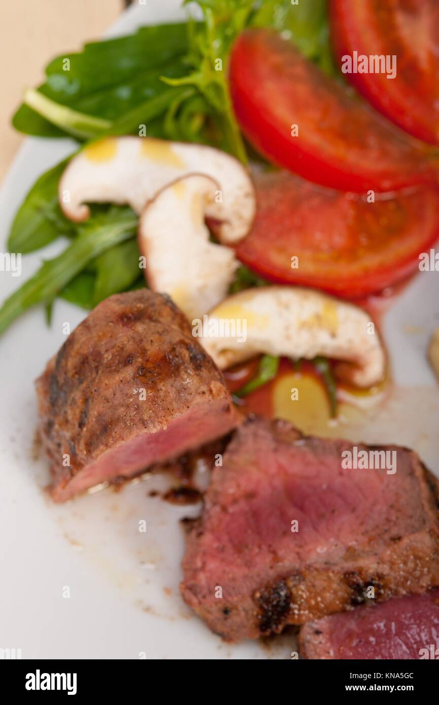 beef filet mignon grilled with fresh vegetables on side ,mushrooms tomato and arugula salad ...