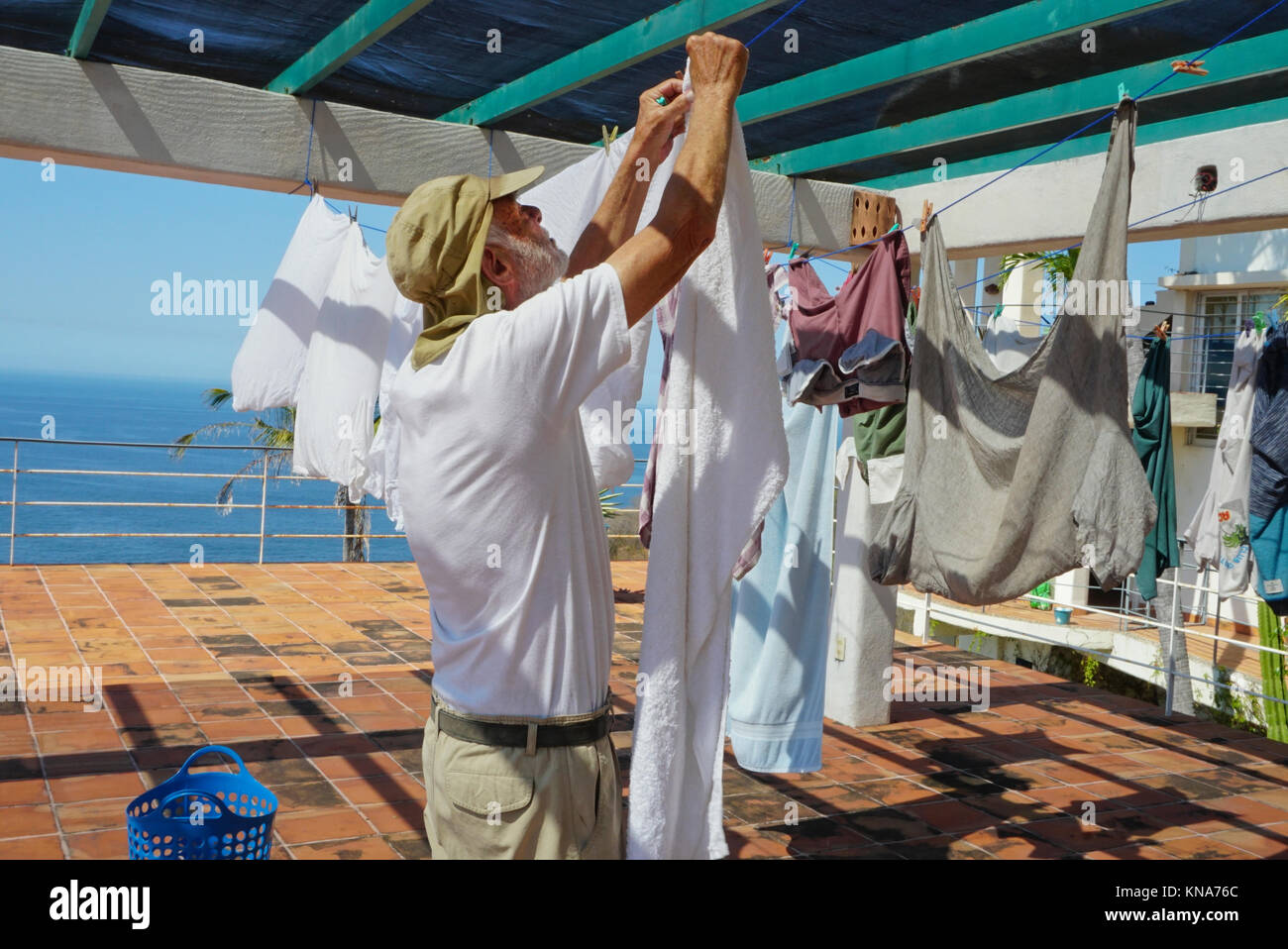 Elderly man hanging laundry Stock Photo - Alamy