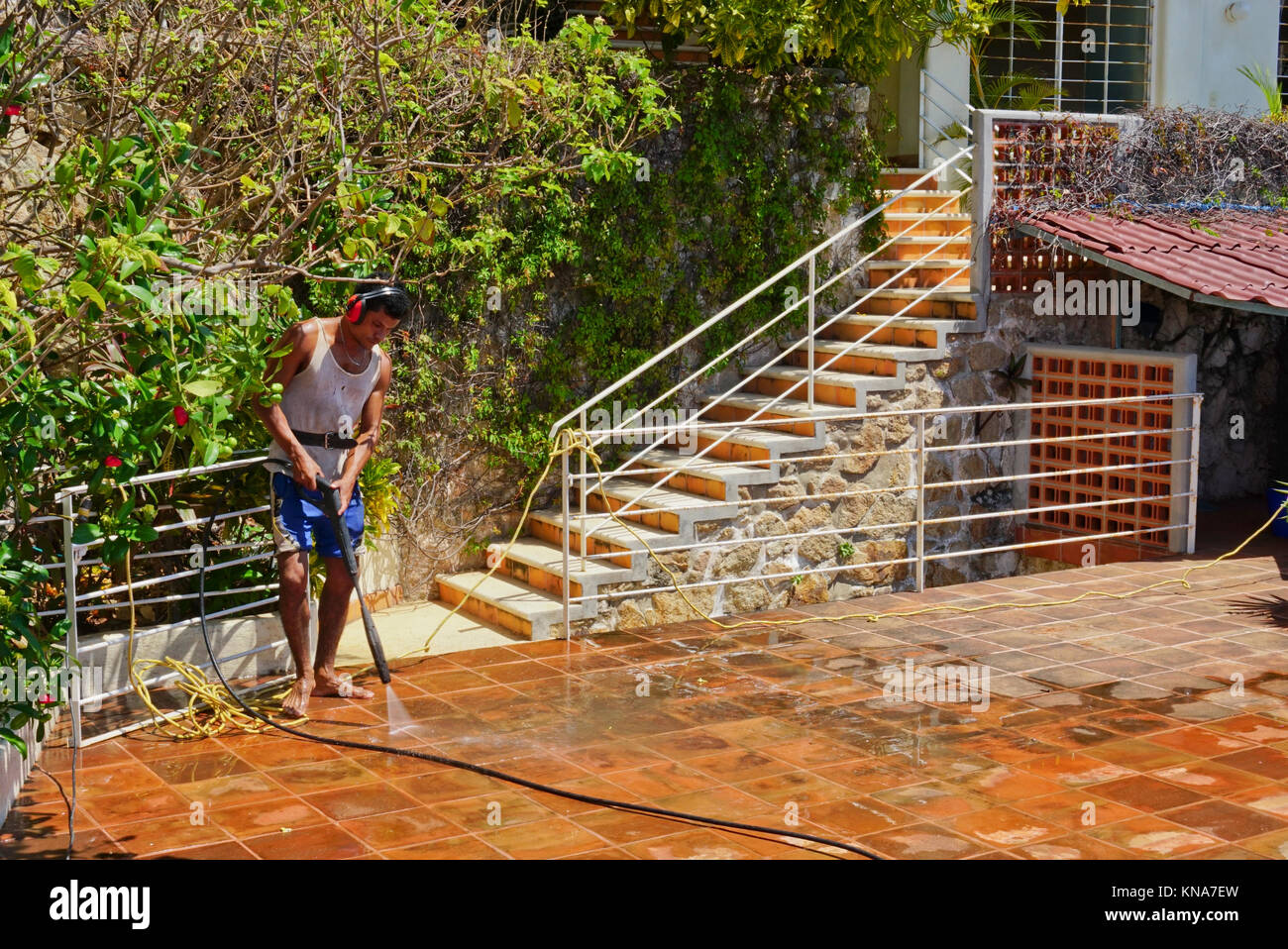 Hired help at Mexican home, Acapulco, Mexico. Pressure washing tiles ...