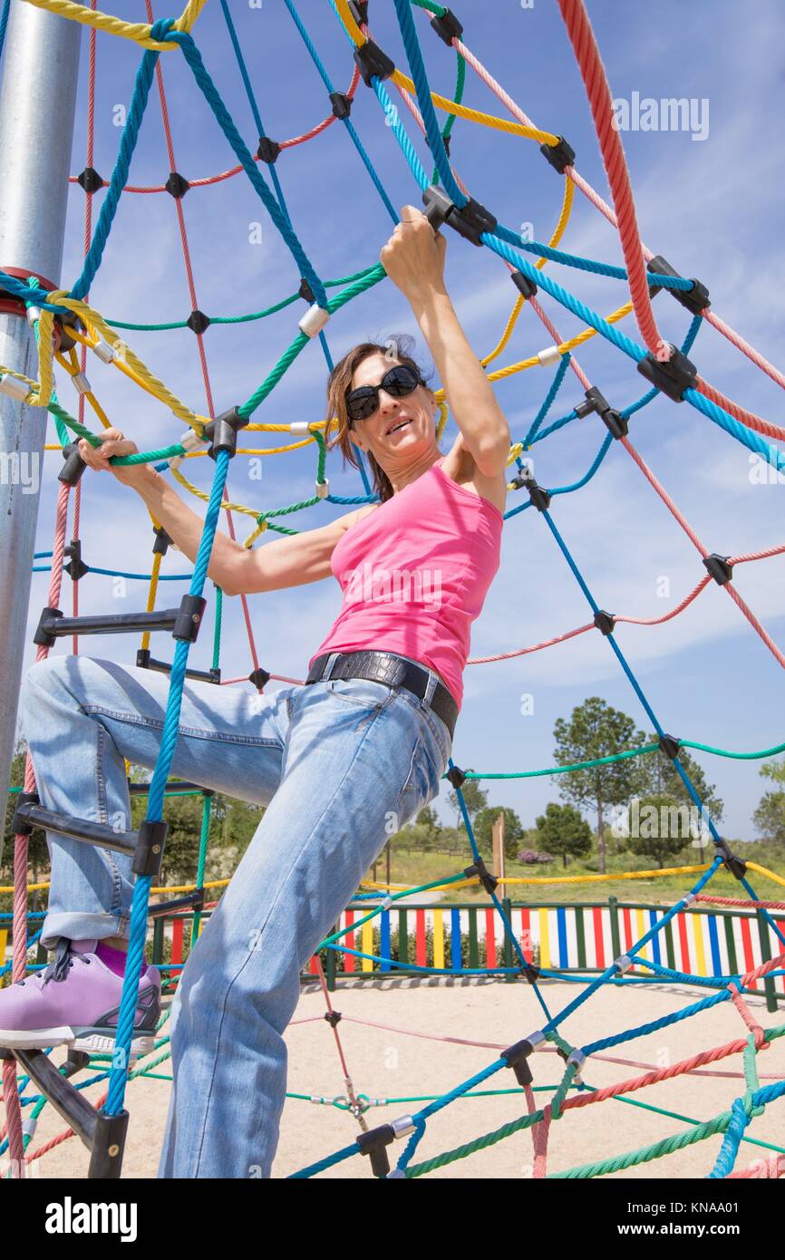adult woman dressed in pink shirt, blue jeans and sunglasses in outdoor ...