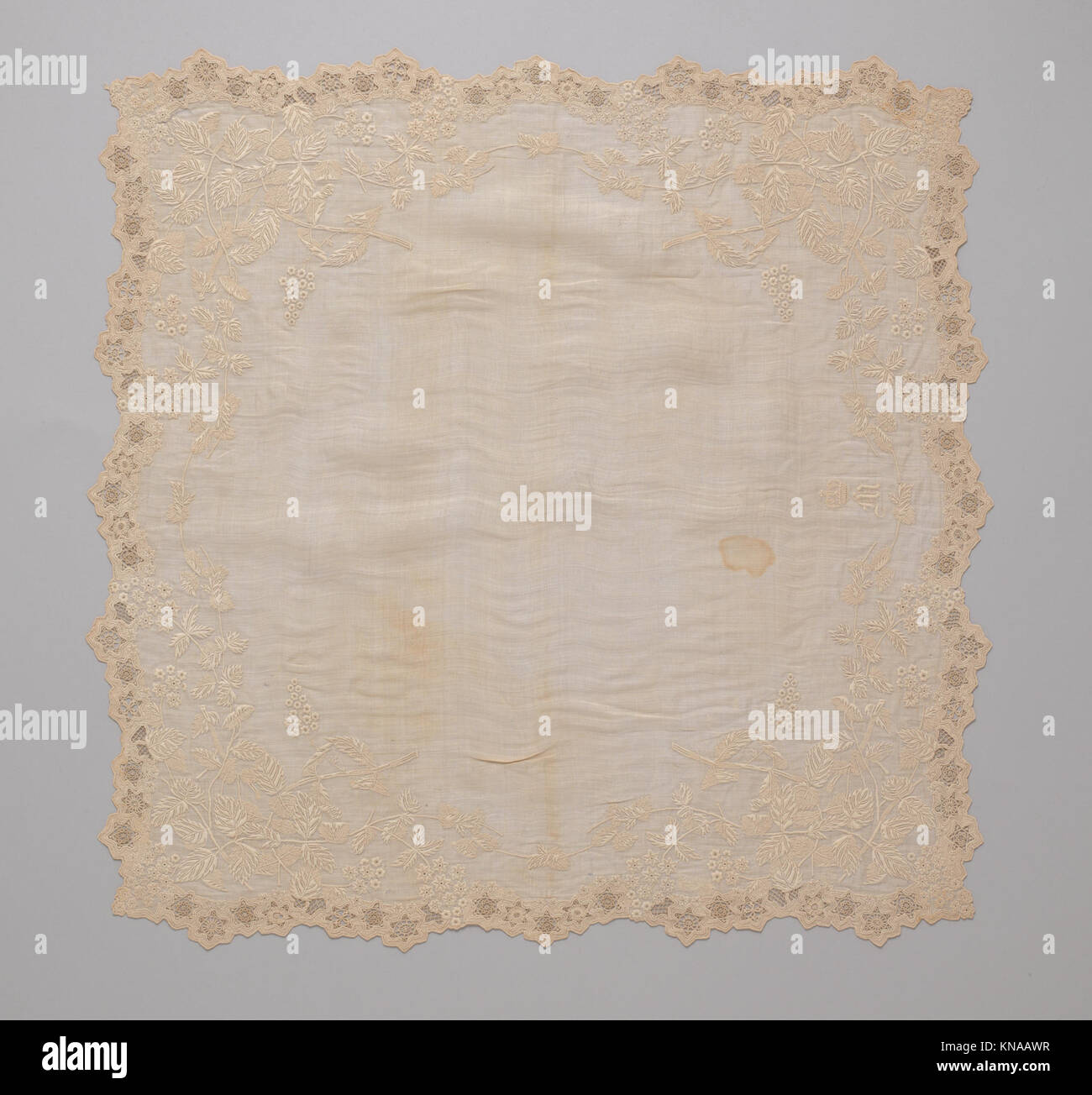 This handkerchief, crafted from fine fabric, is an example of delicate ...