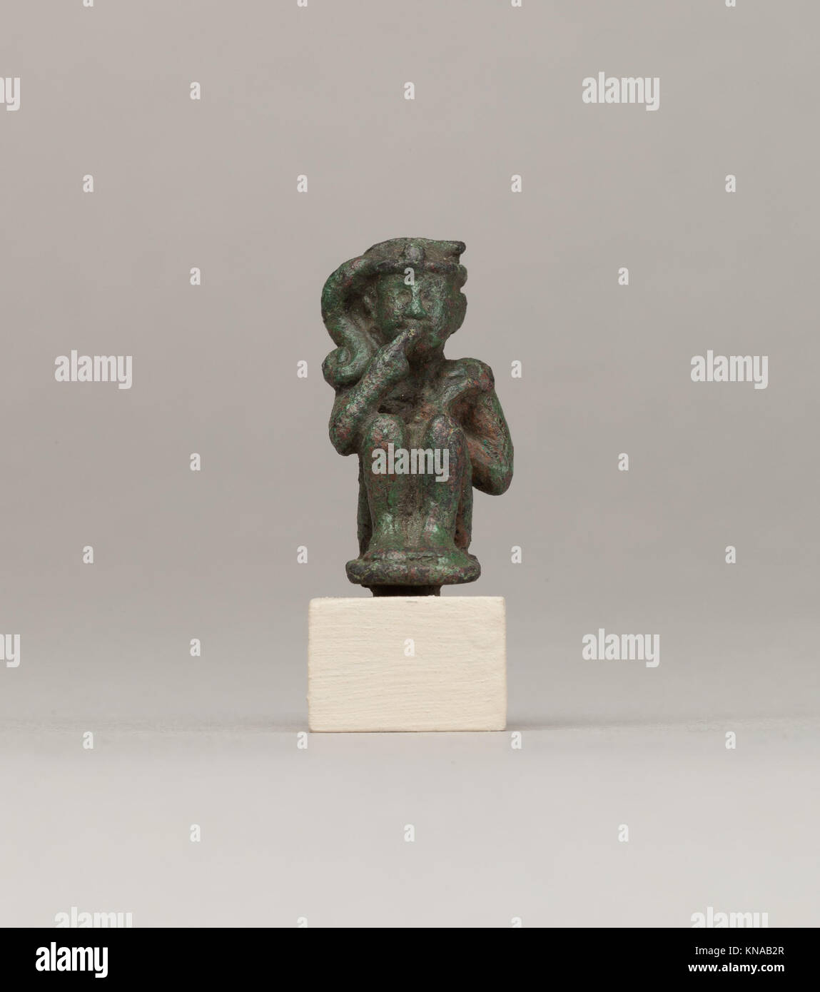 This sculpture depicts a crouching child god holding a scepter ...