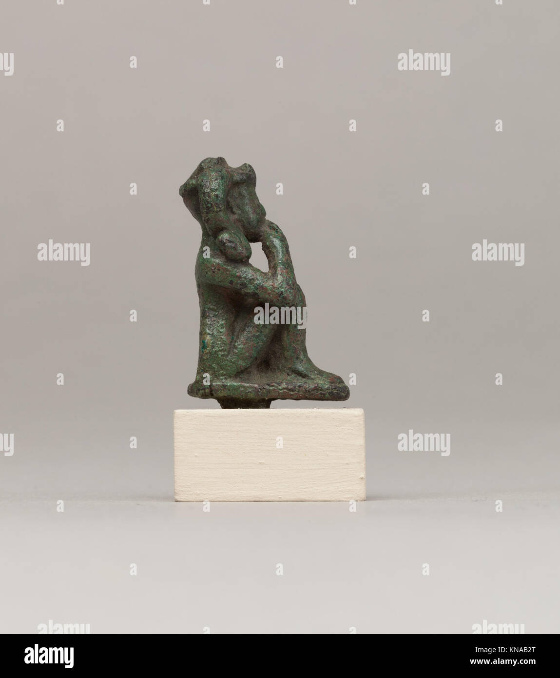 This sculpture depicts a crouching child god holding a scepter ...