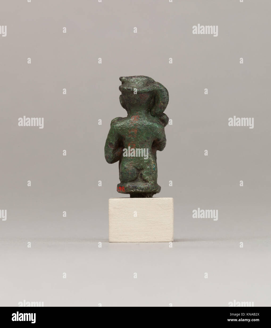 This sculpture features a crouching child god holding a scepter ...