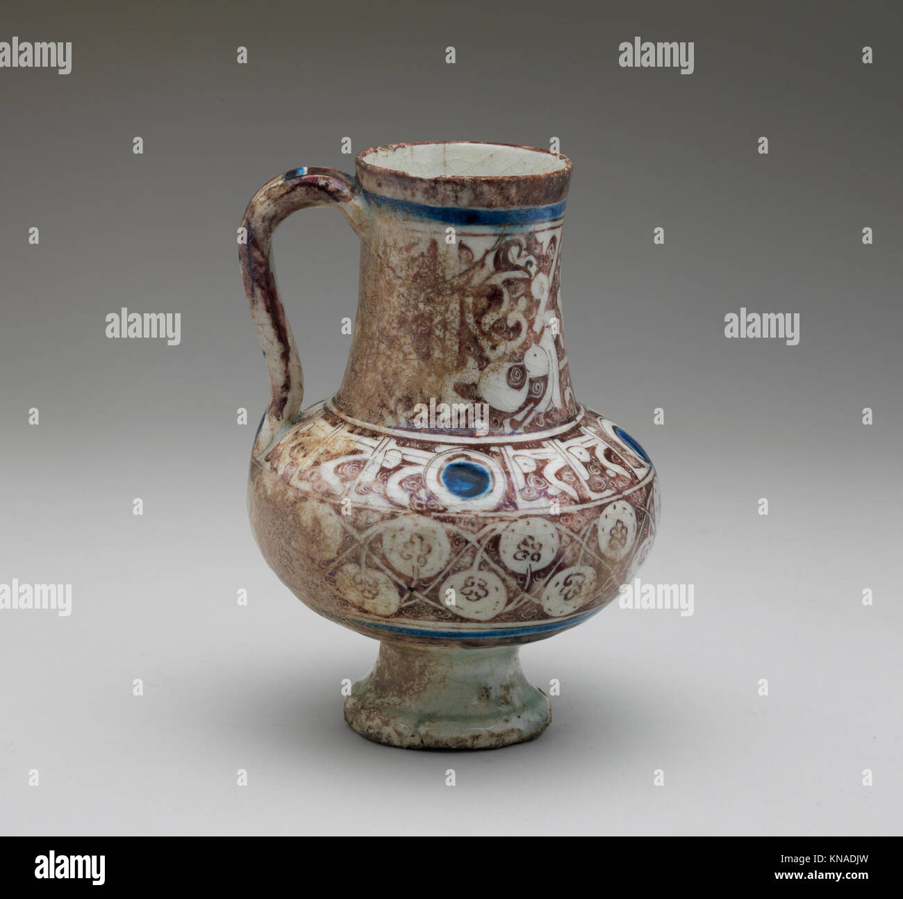 A metal ewer inscribed with 'al-izz' in floriated Kufic script ...