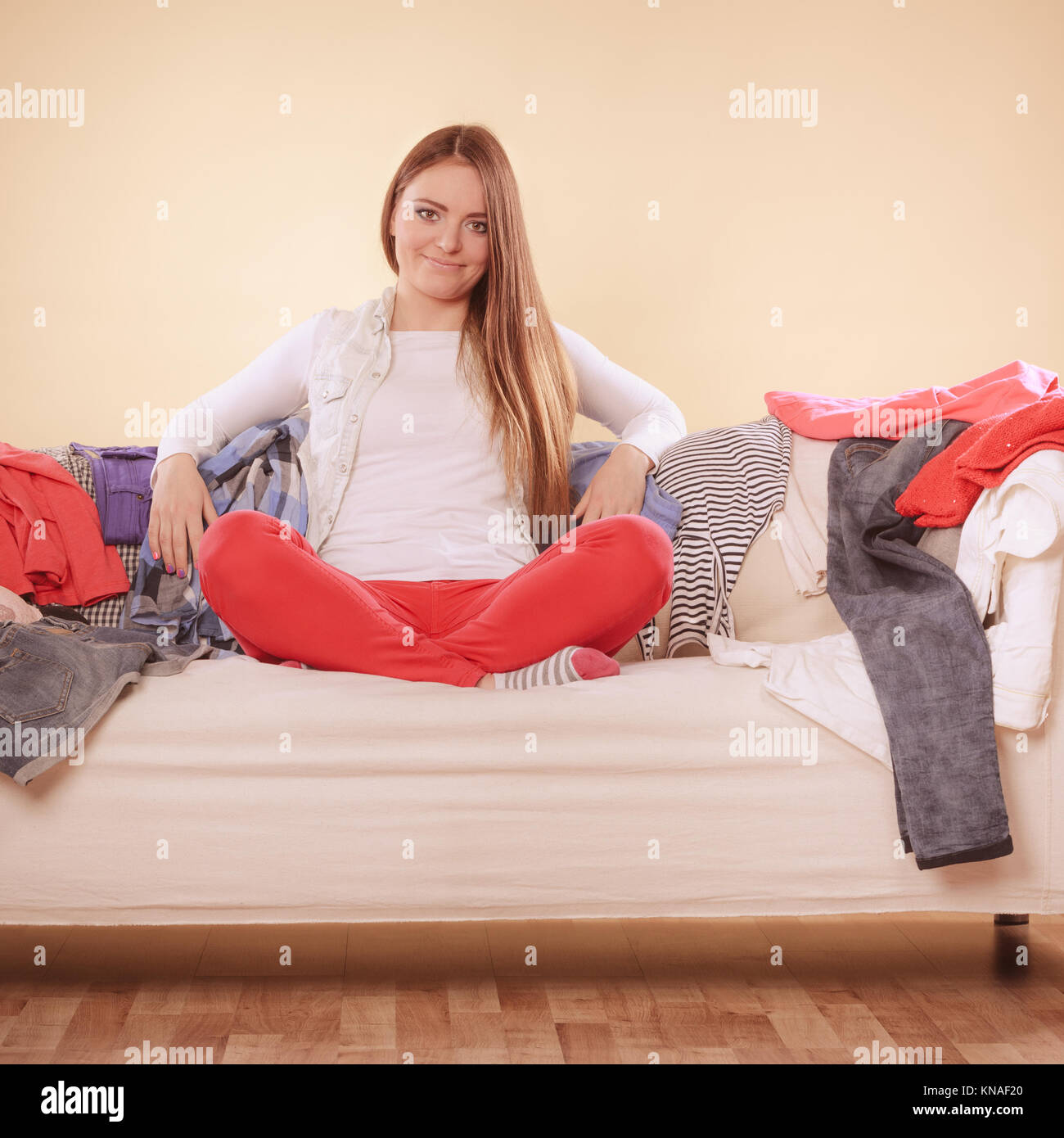 Woman sitting on sofa couch in messy living room. Young girl surrounded ...