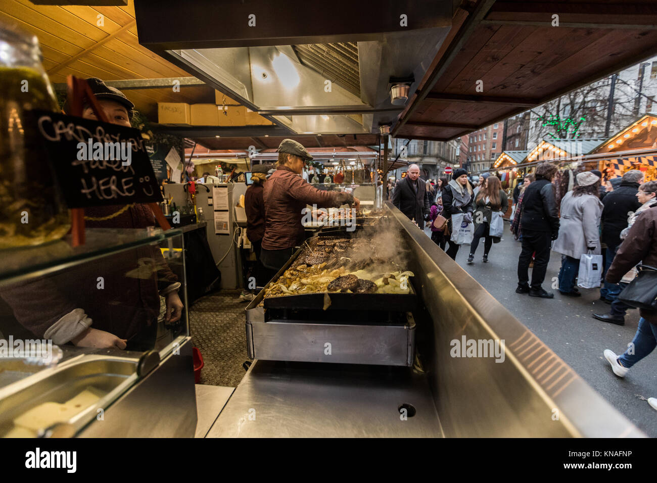 Market stall traders serve food and drink to customers at Manchester ...