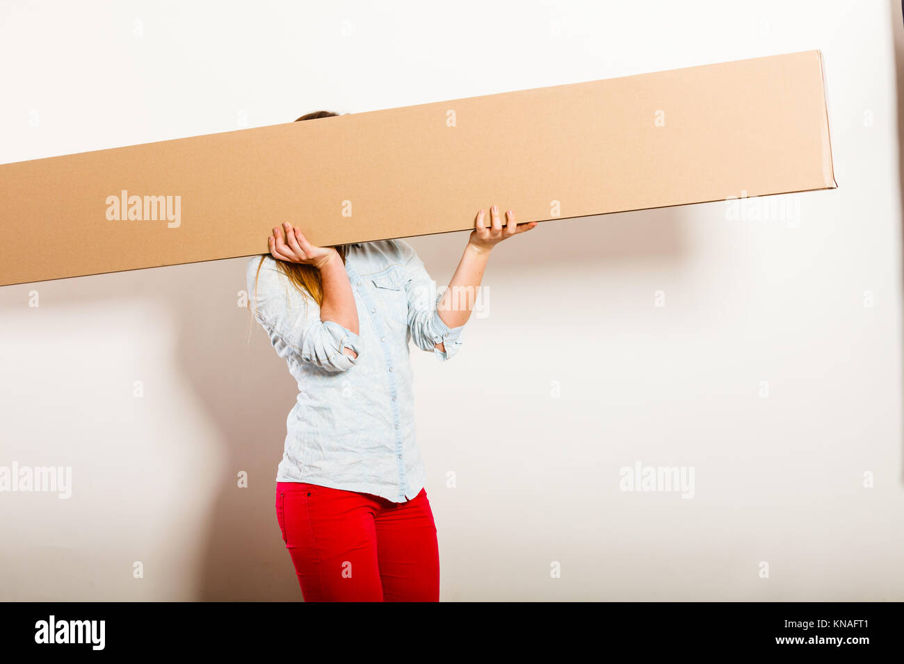 Woman moving into new apartment house carrying carton box with ...