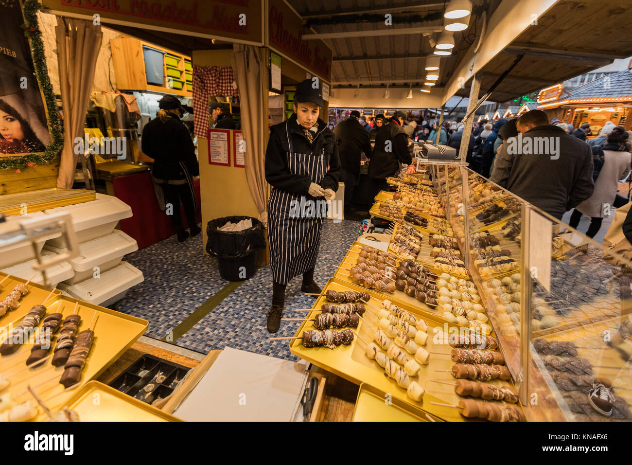 Market stall traders serve food and drink to customers at Manchester Christmas Markets Around ...
