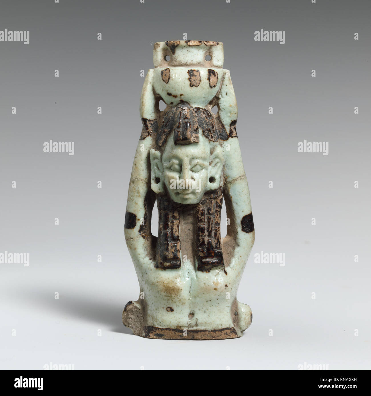 This East Greek faience statuette fragment depicts a woman carrying a ...