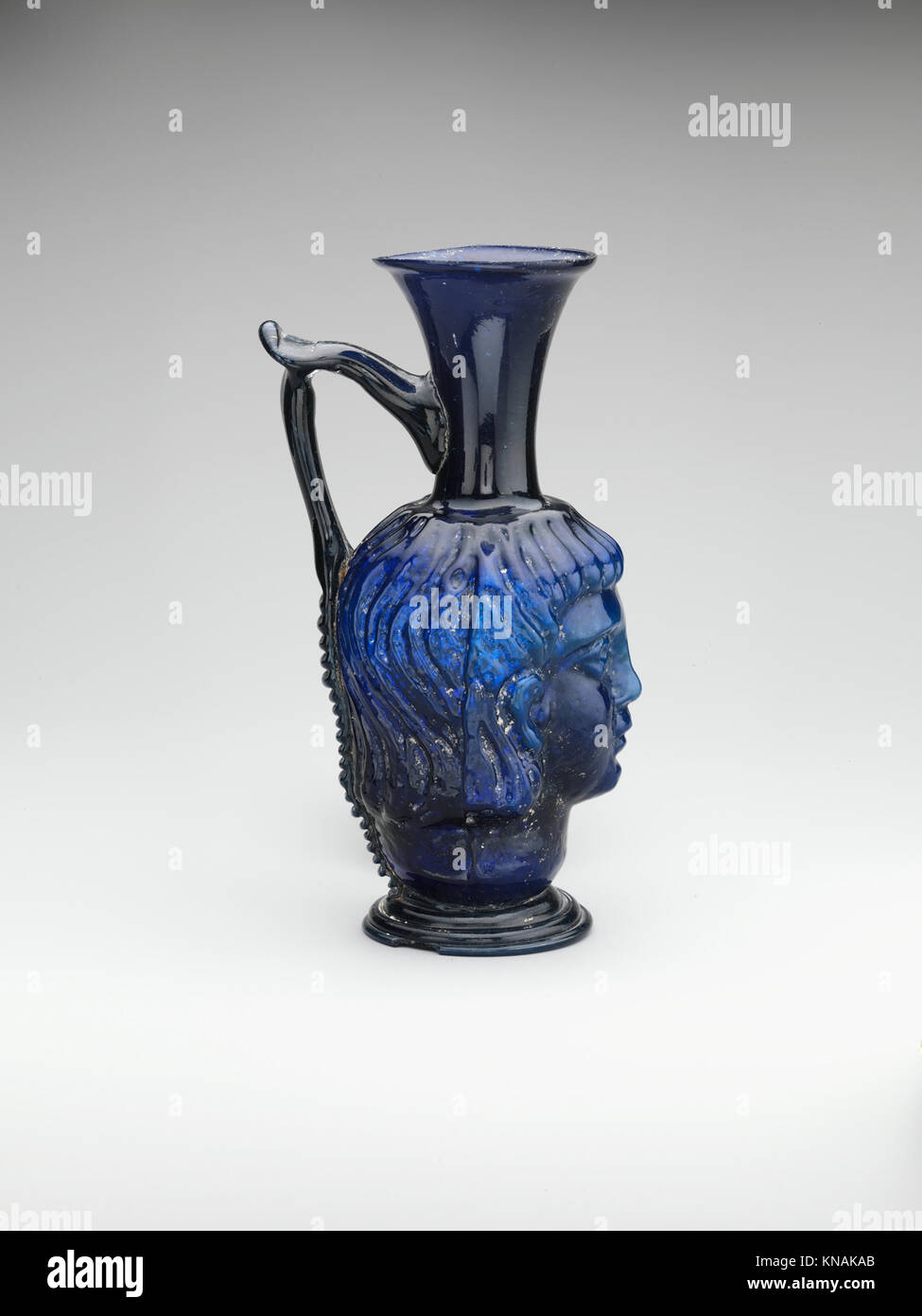 A glass head flask, a small container designed with a human head shape ...