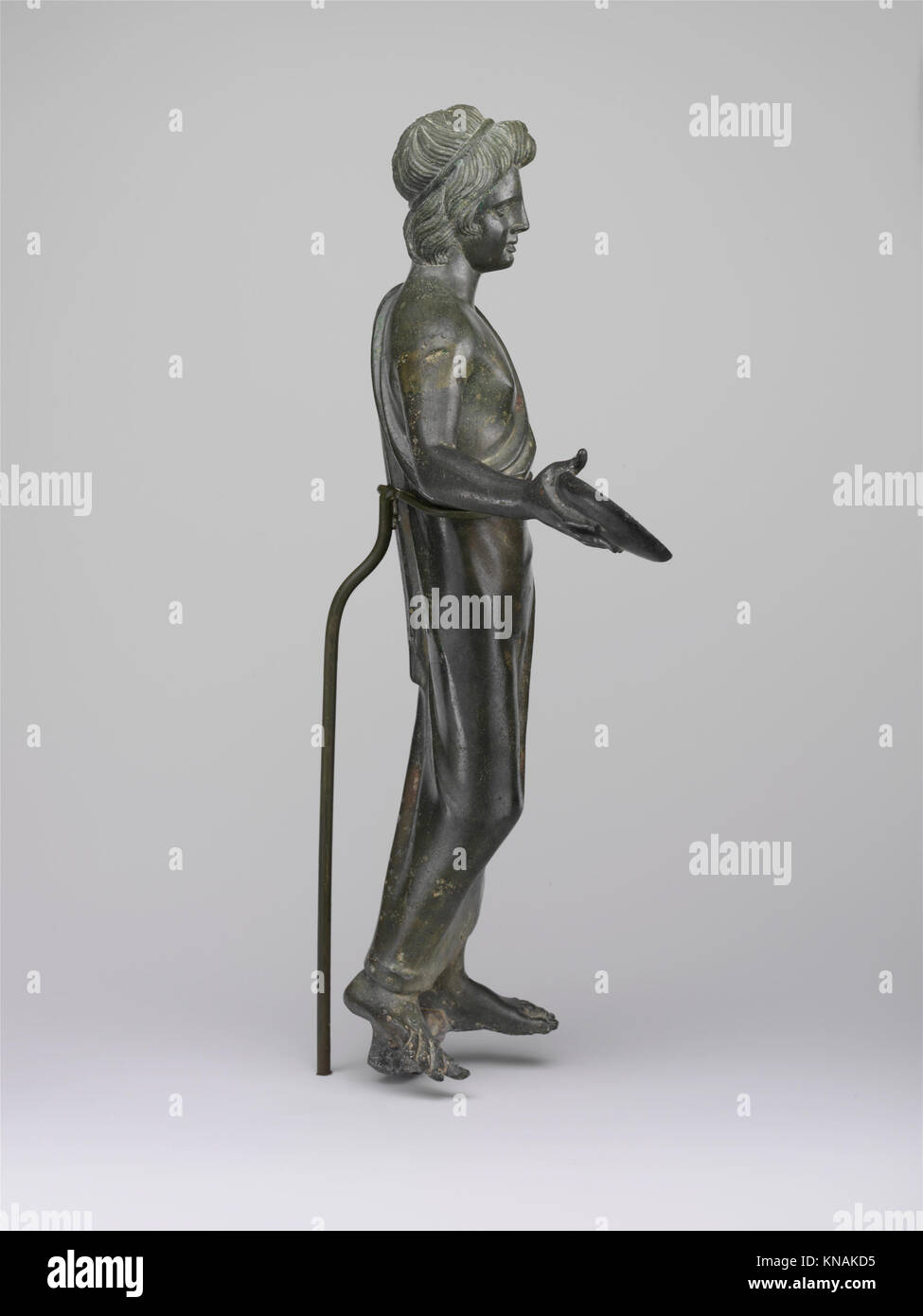 A bronze statuette of a priest, depicting a religious figure in ...