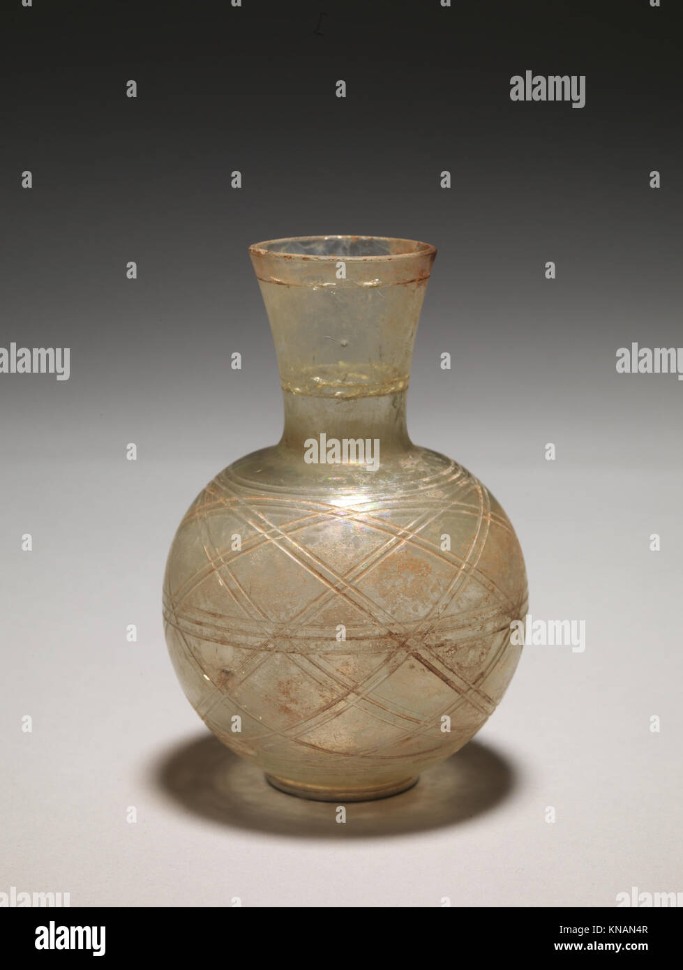 This glass flask, a functional and decorative object, features ...