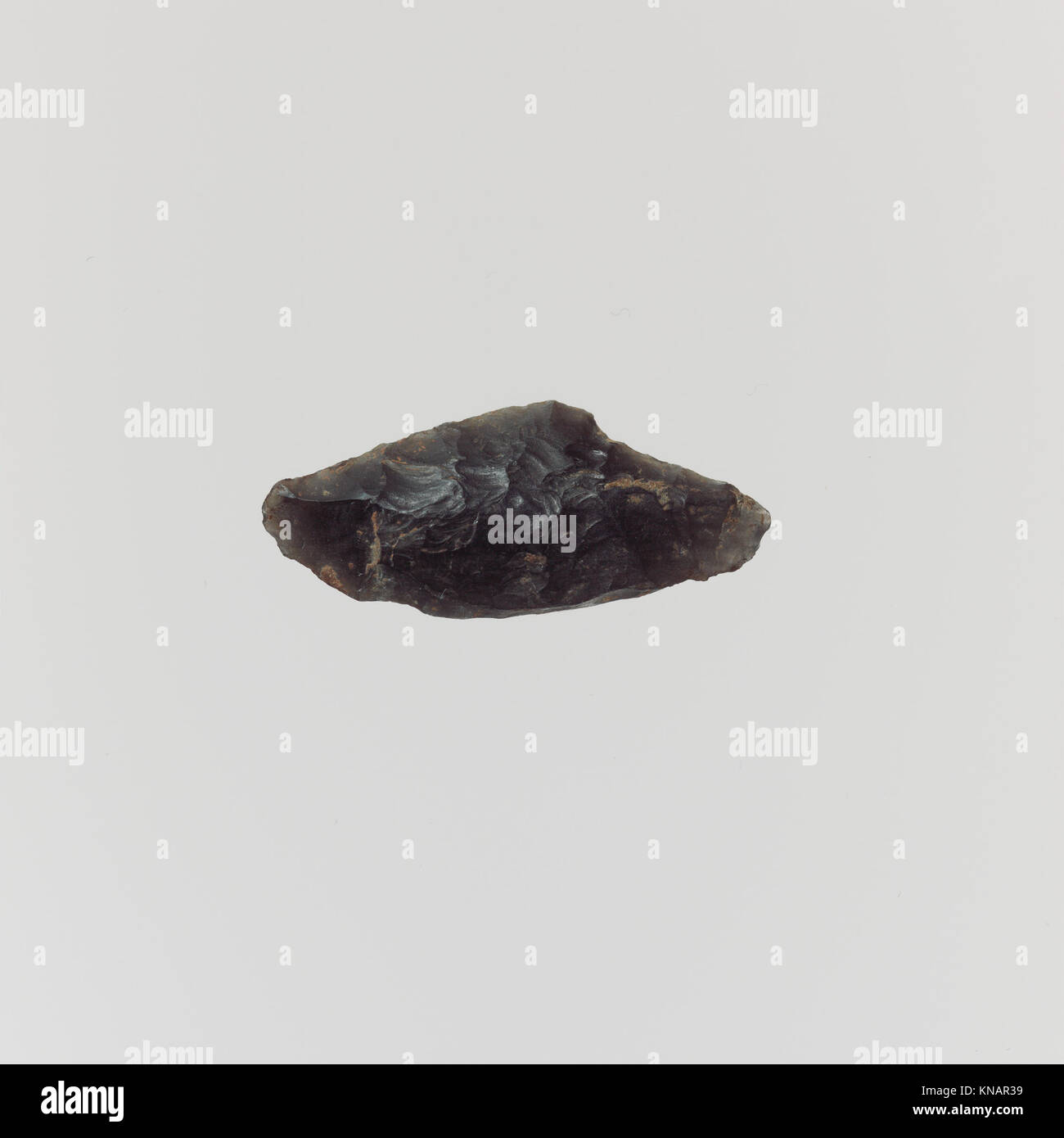 The flint arrowhead is a prehistoric tool with sharp edges, reflecting ...