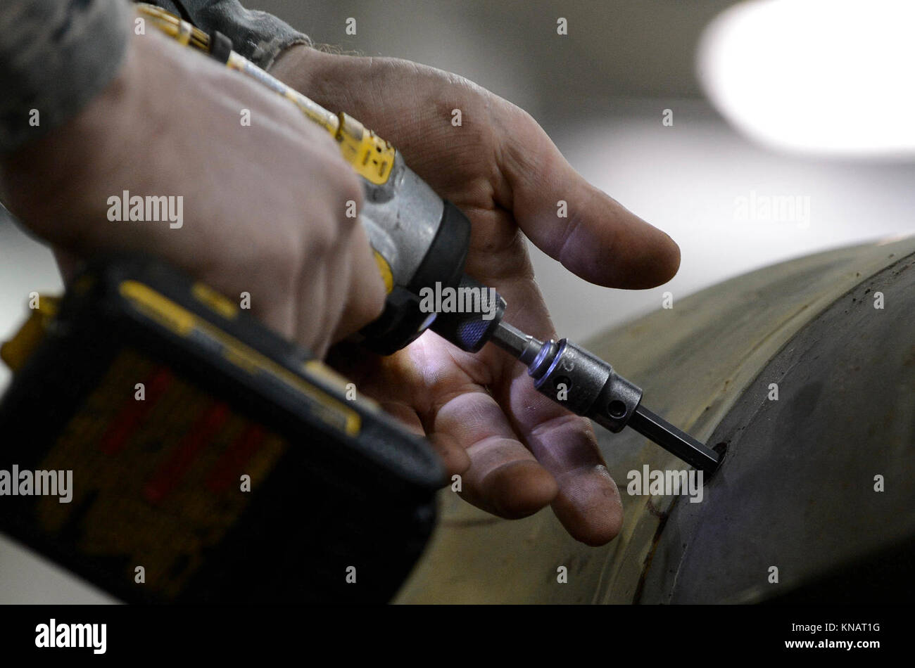 An Airman from the 2nd Munitions Squadron Production Flight tightens a ...
