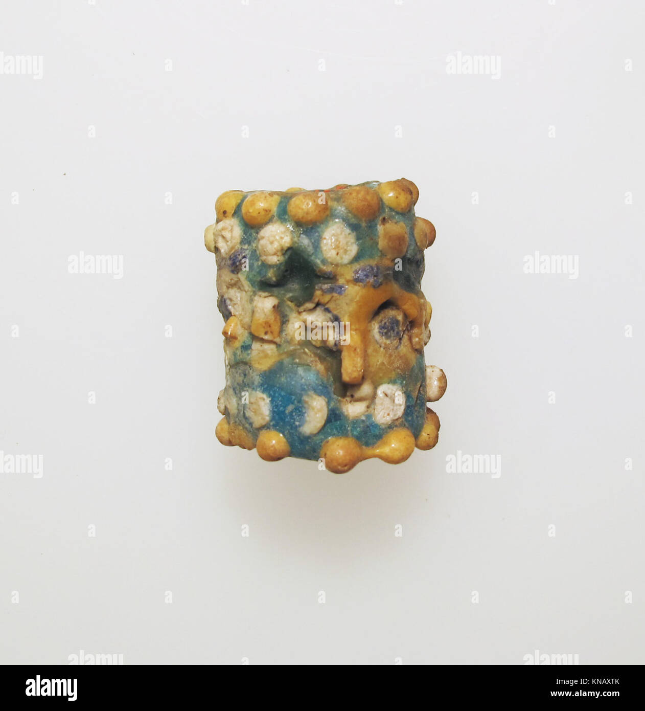 This glass face bead features a unique design, depicting facial ...