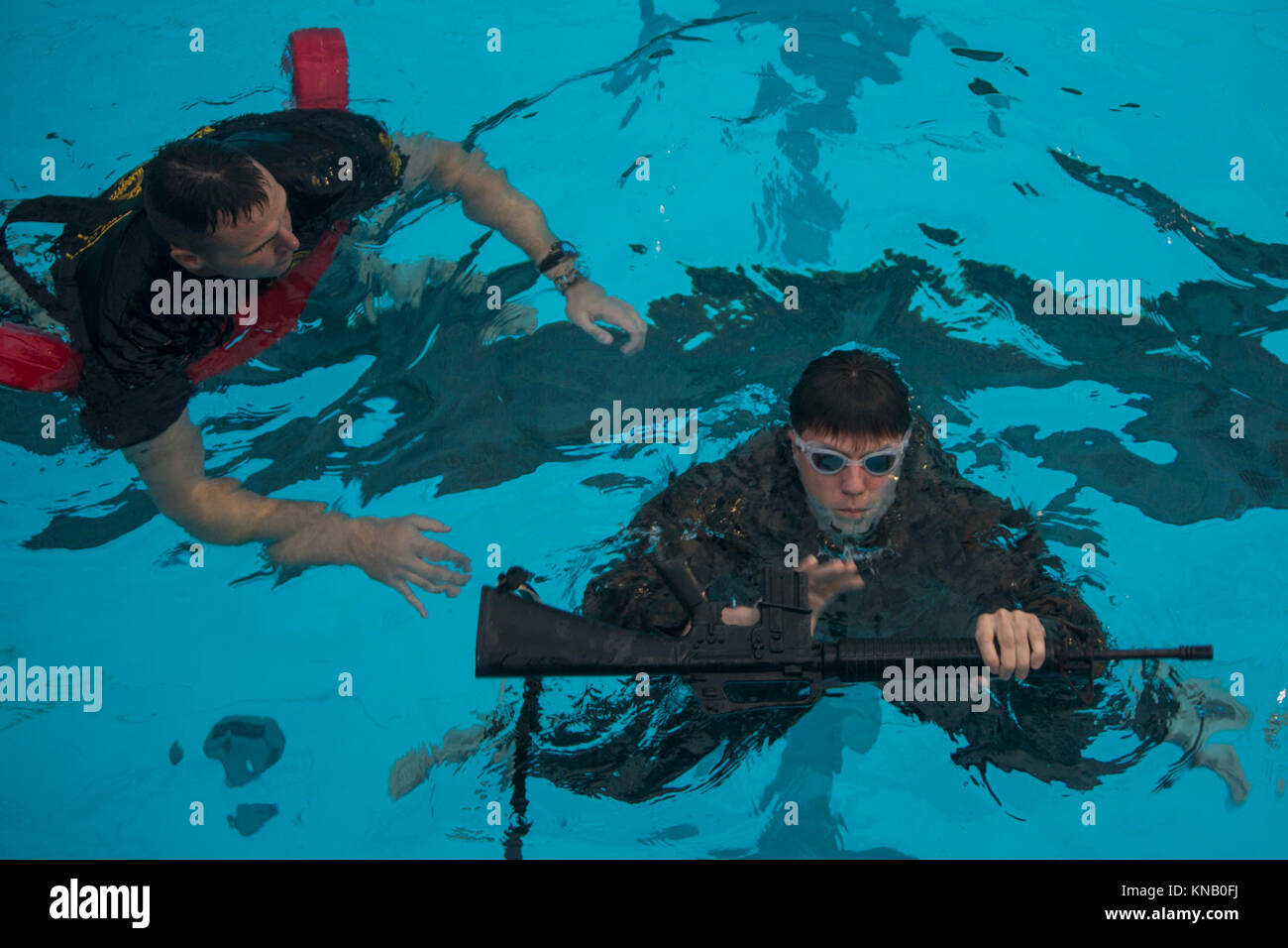 A Marine with 3rd Reconnaissance Battalion supervises a Marine carrying ...