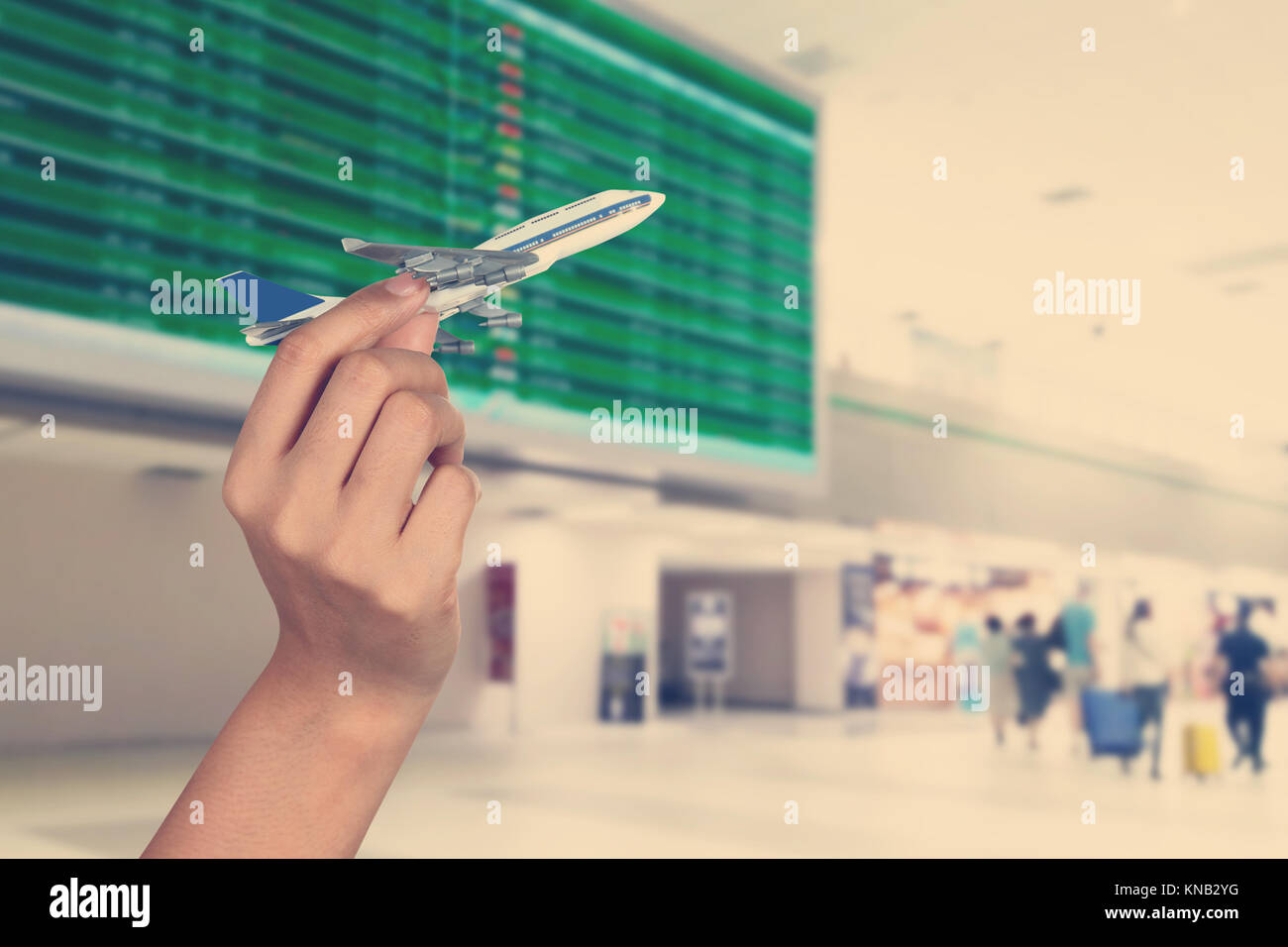 hand holding airplane and flight information board , travel concept ...