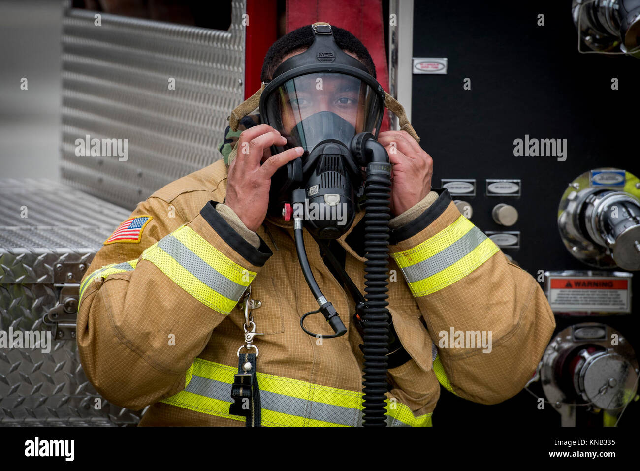 A 374th Civil Engineer Squadron firefighter prepares to remove his gas ...
