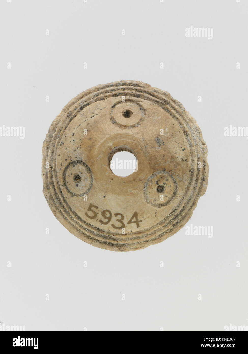 This bone spindle whorl is an artifact from the ancient world ...
