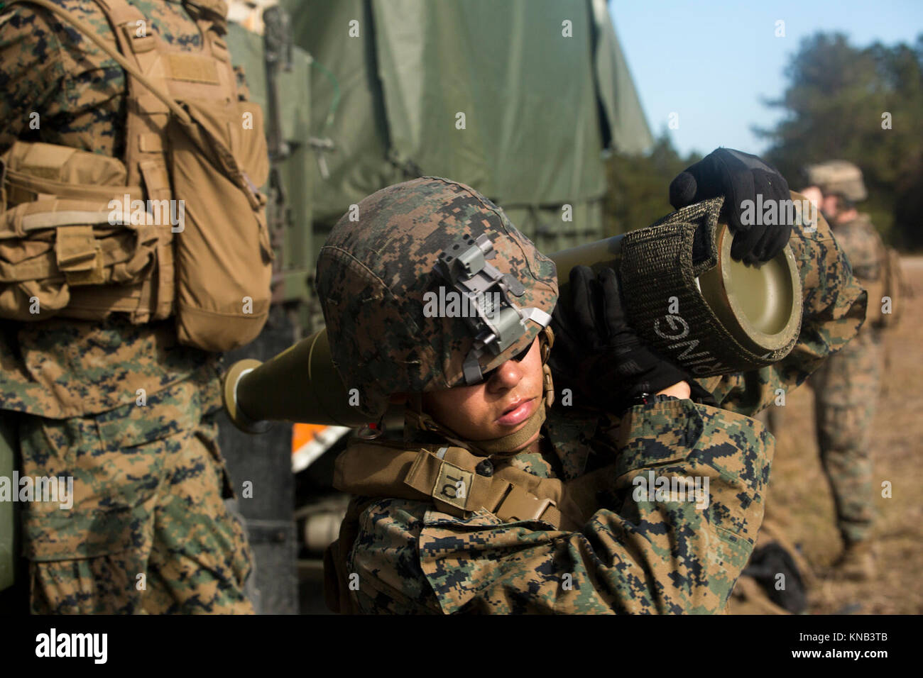 A Marine carries a 104lb artillery round for an M777 A2 howitzer during ...