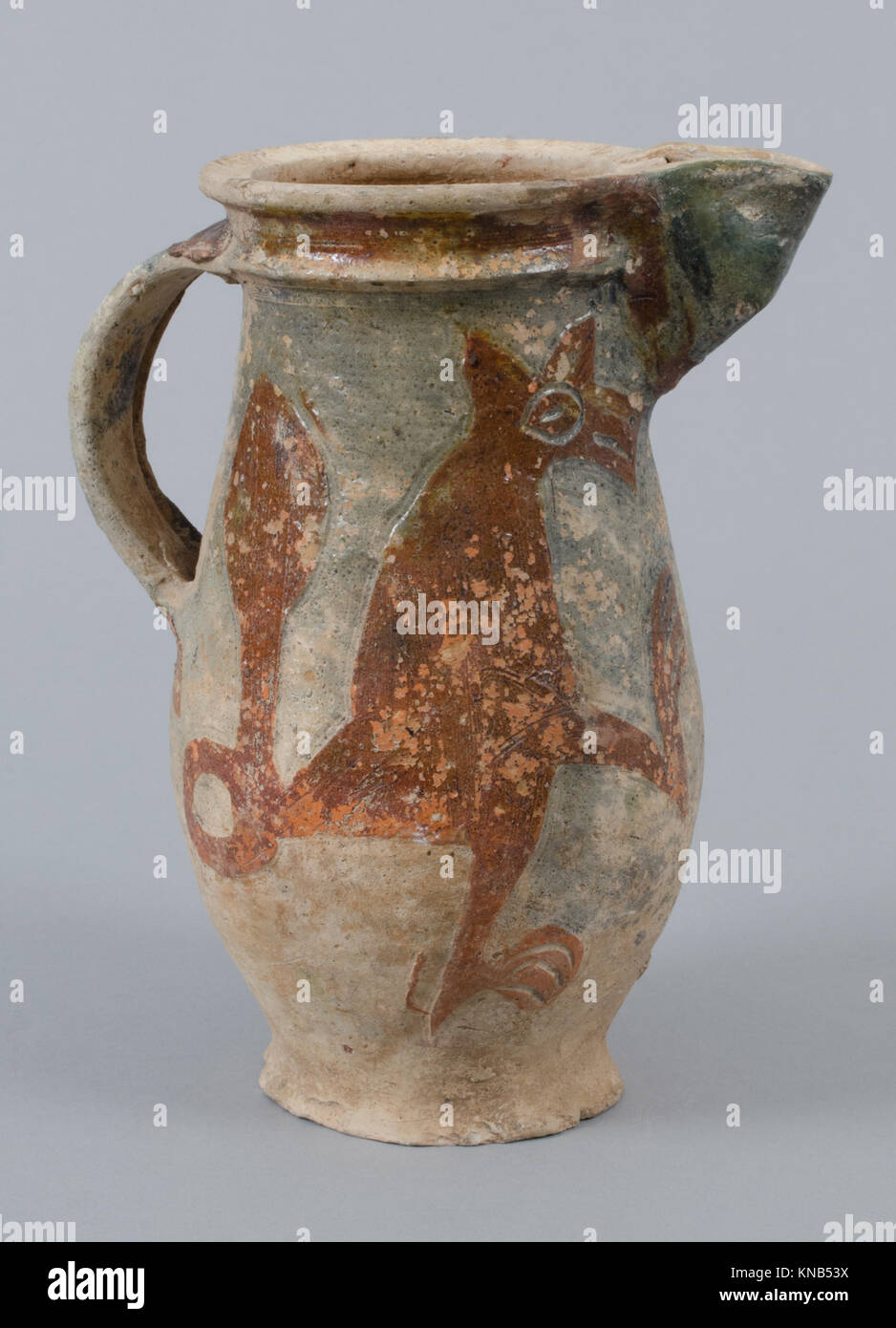 This barrel-shaped jug displays a fox and cockerel motif, illustrating ...