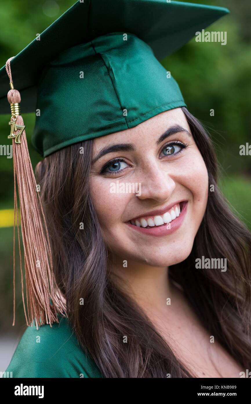 Pretty girl posing for a graduation photo on campus during her senior ...