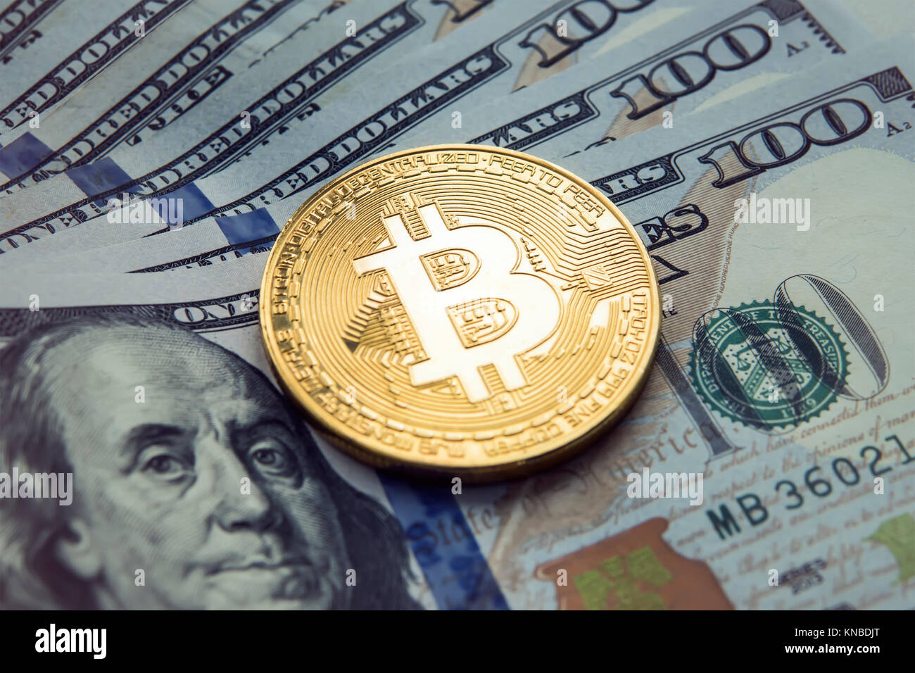Golden bitcoin with Benjamin Franklin portrait from one hundred ...