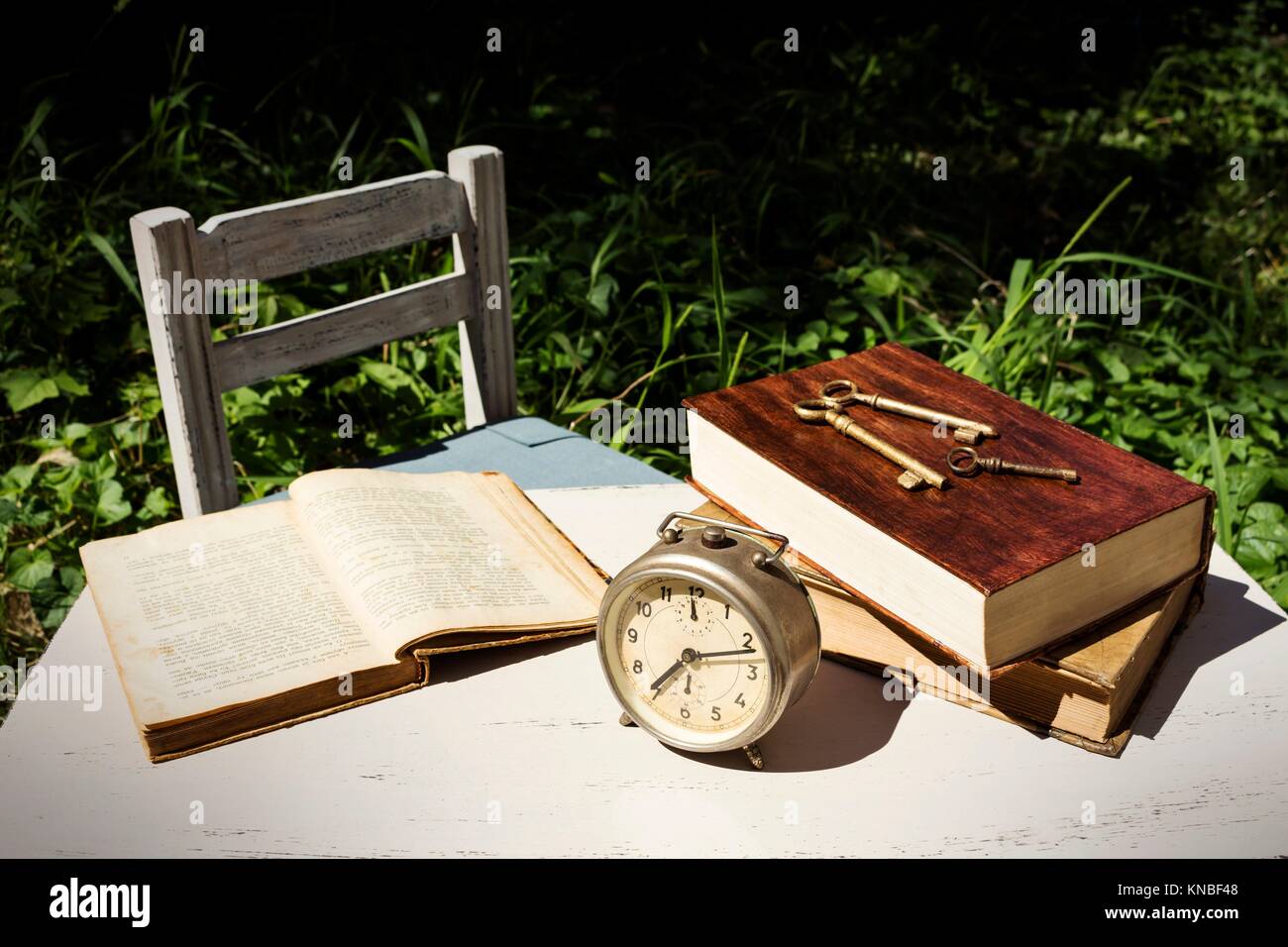 Vintage still life with old alarm clock, keys and books on a white ...