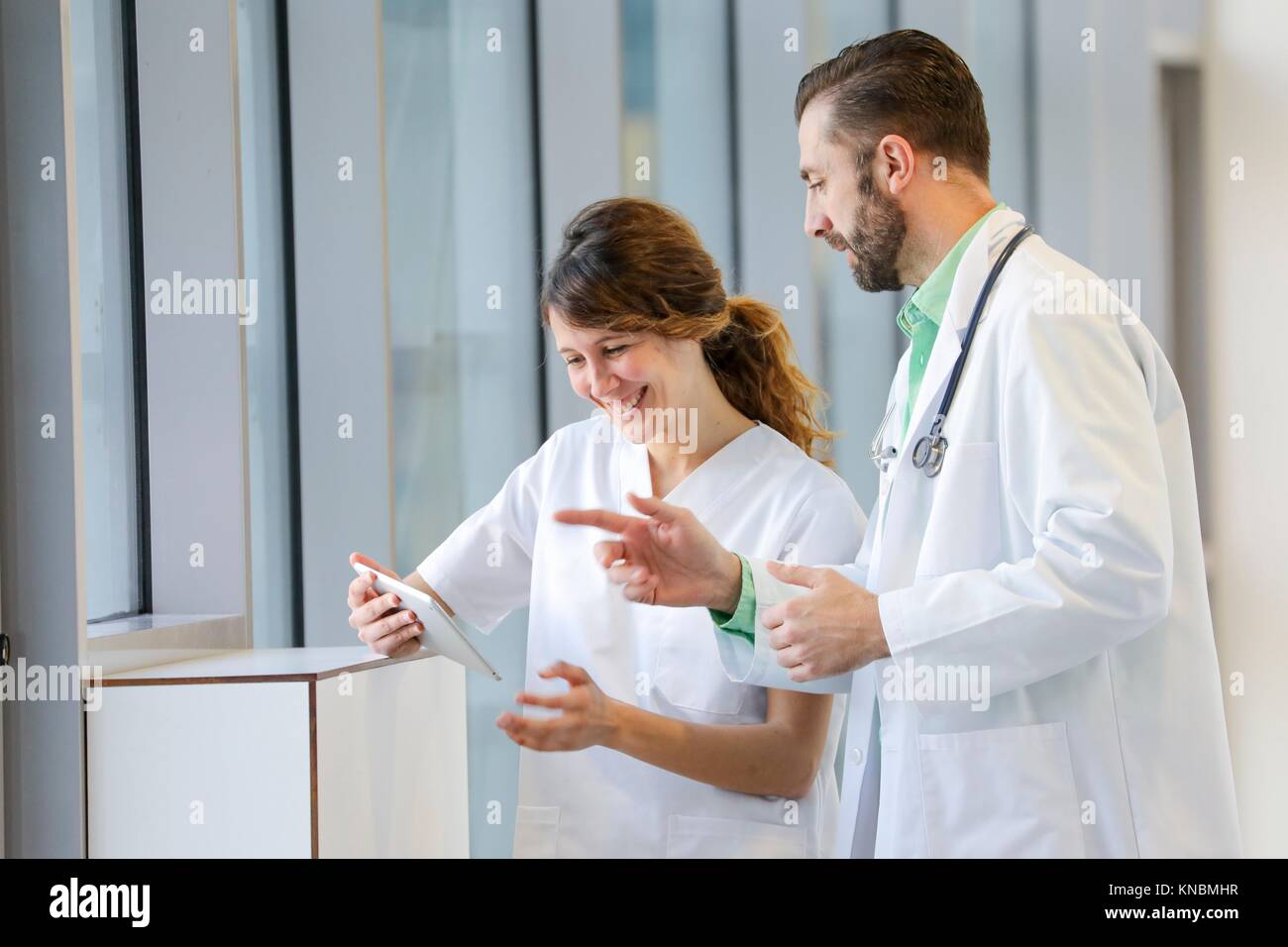Doctor and nurse with tablet talking in corridor, Hospital Stock Photo ...