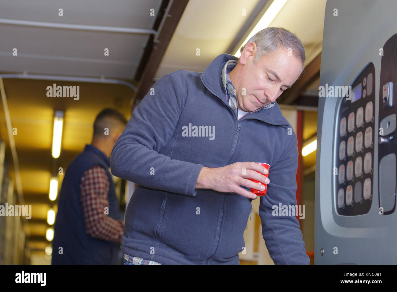 Man getting drink from vending machine Stock Photo - Alamy