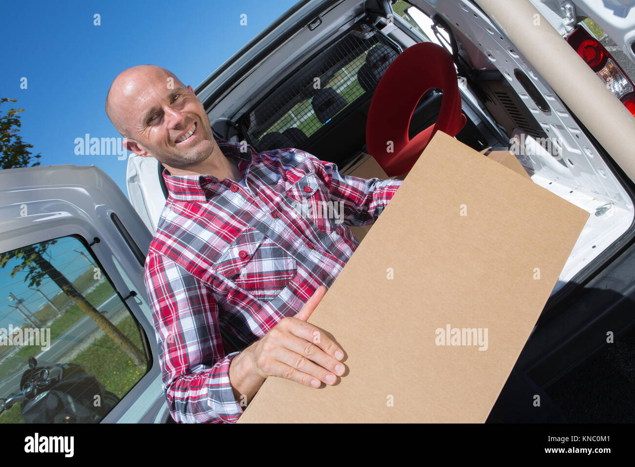 young male deliverer unloading boxes from car Stock Photo - Alamy