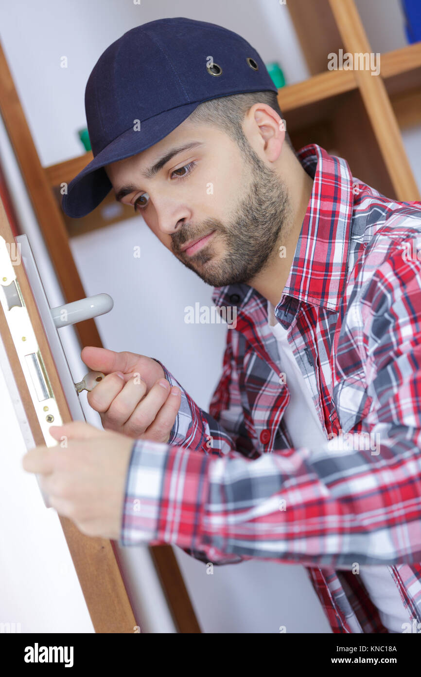 young man fixing the door Stock Photo - Alamy