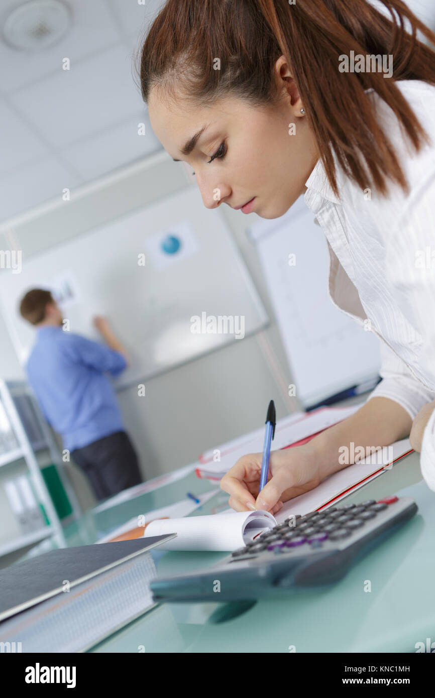Young woman doing calculations Stock Photo - Alamy