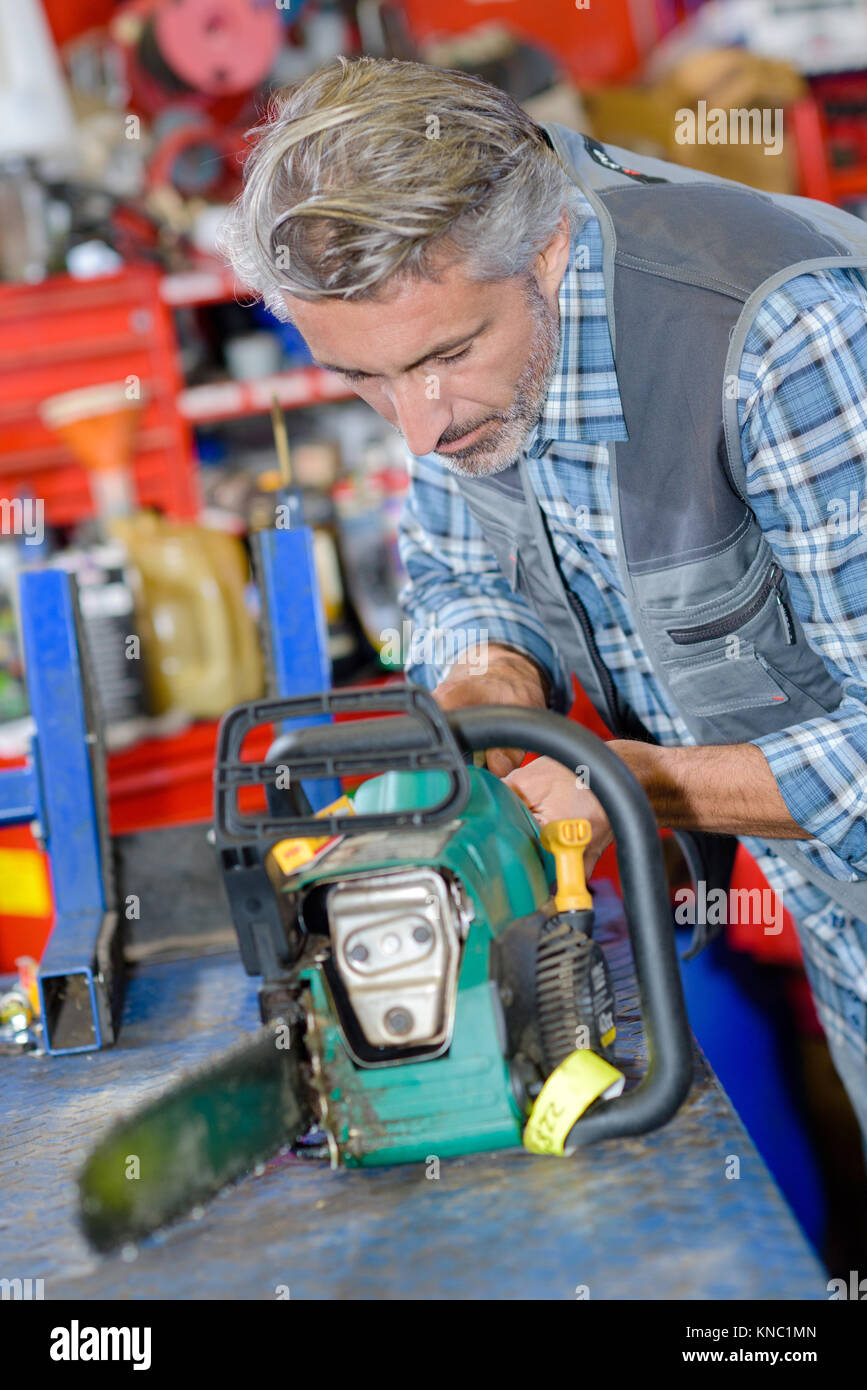 man worker with chainsaw in workshop Stock Photo - Alamy