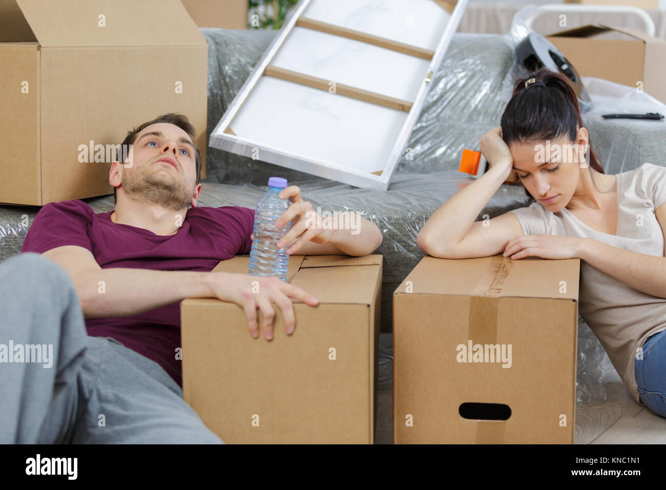 tired couple with boxes moving into new home apartment Stock Photo - Alamy