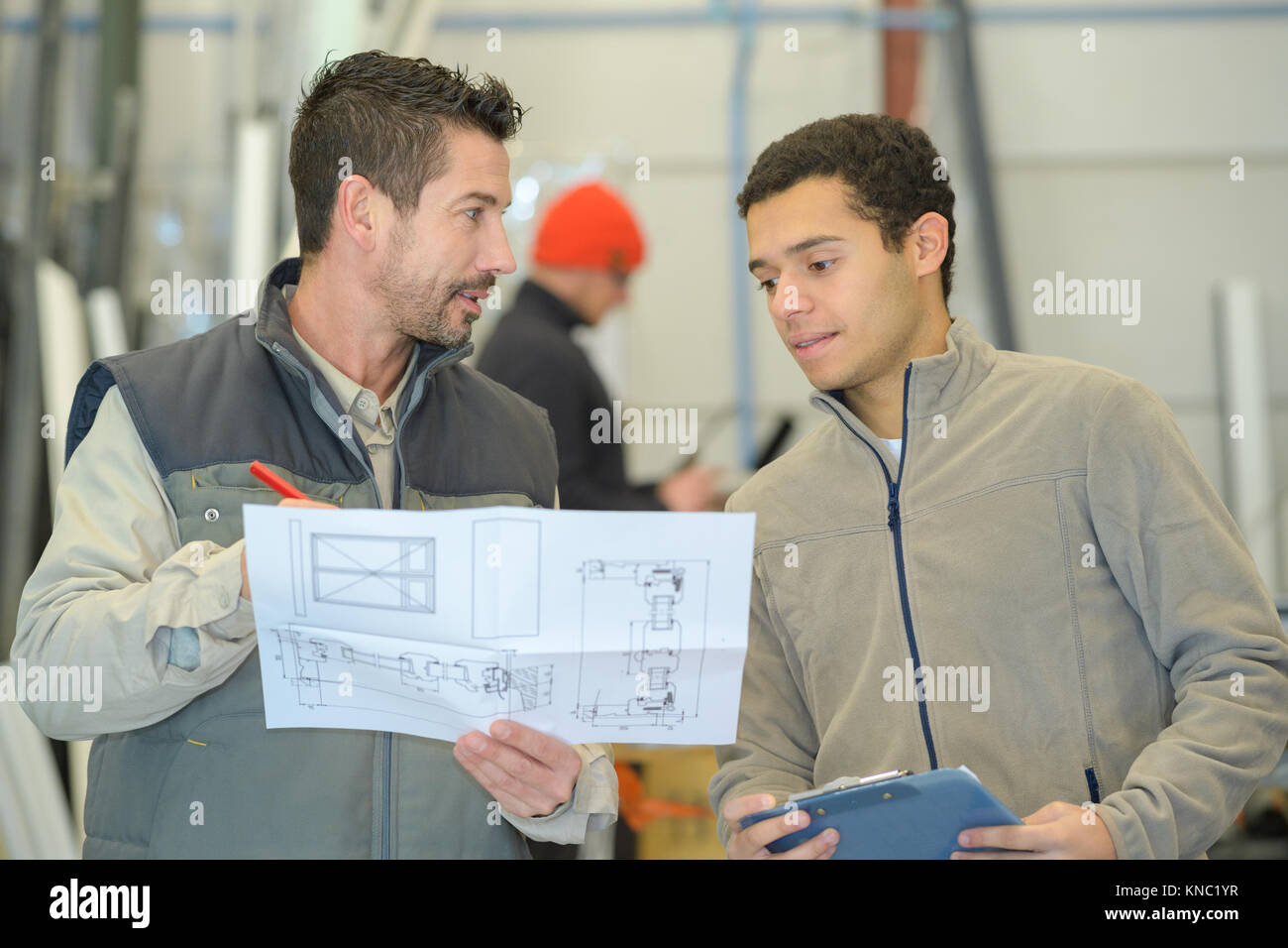 male engineer and worker checking indoor building construction site ...