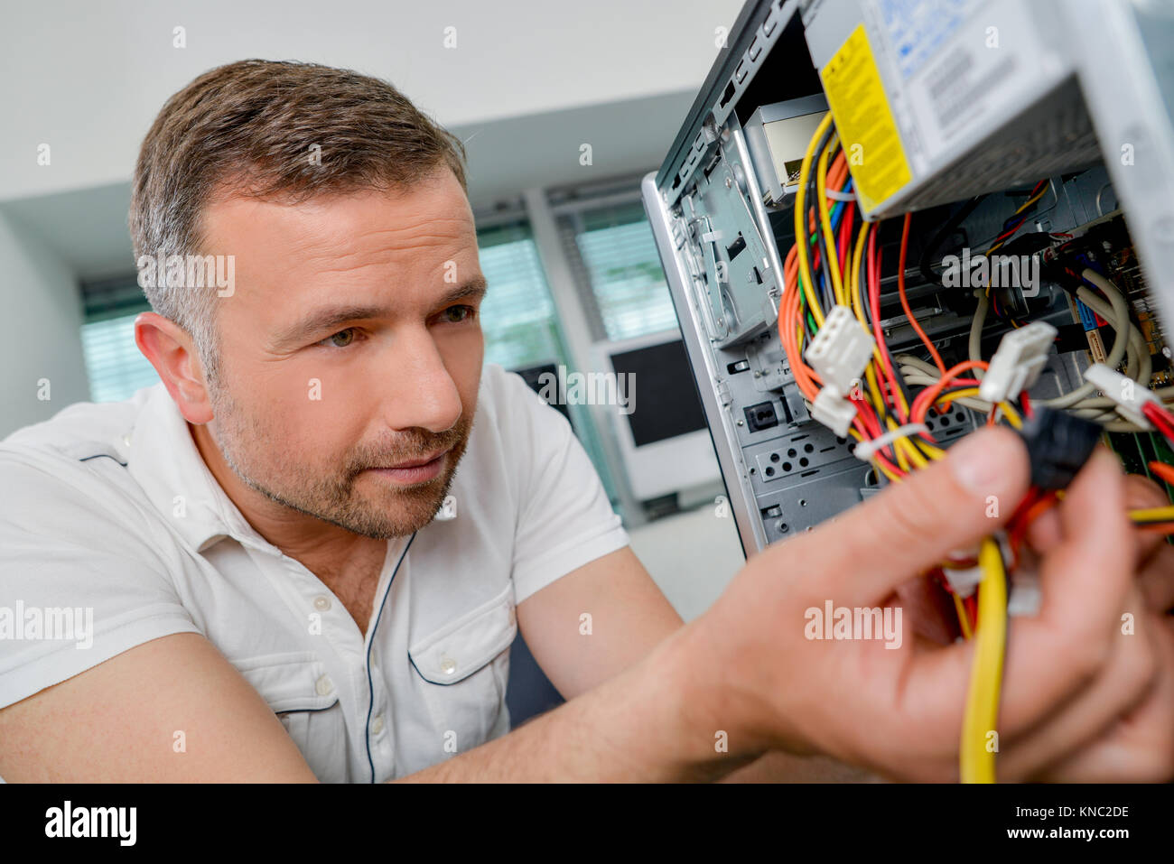 Man inspecting wiring of computer Stock Photo - Alamy