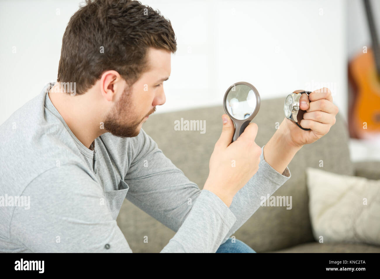 astonished man looking through a magnifying glass Stock Photo - Alamy