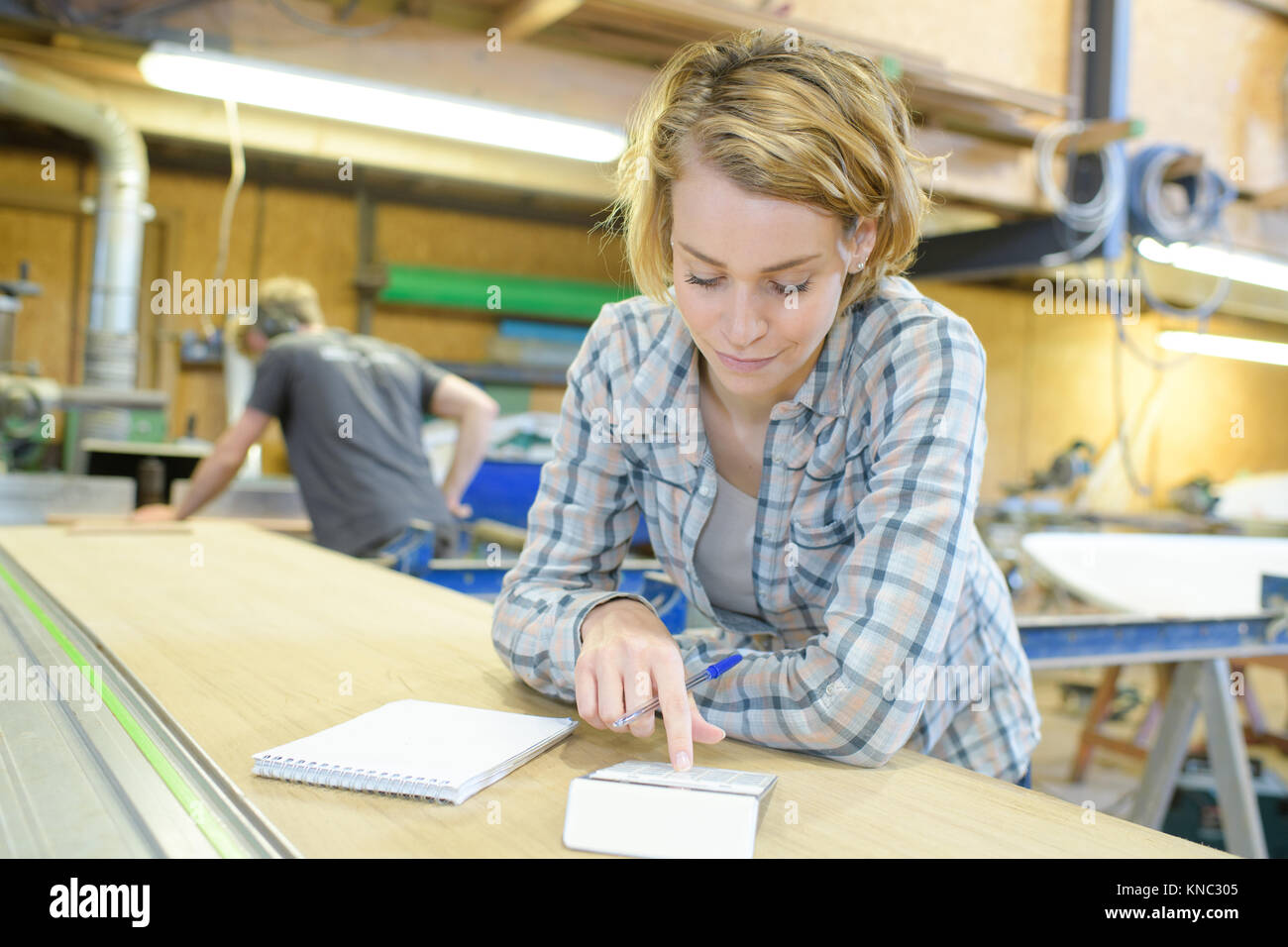 female worker using calculator in warehouse Stock Photo - Alamy