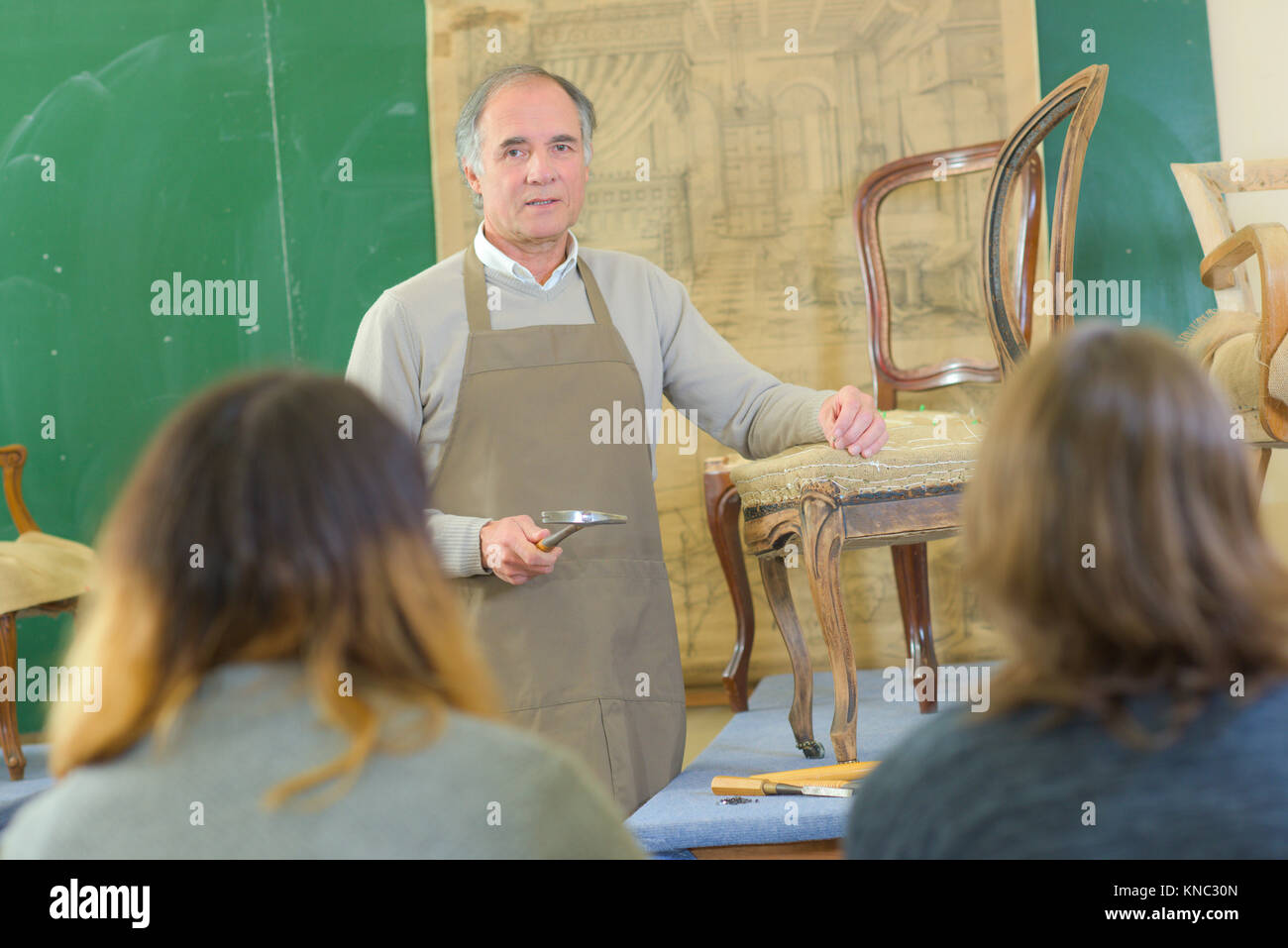 teacher showing students how to repair a chair Stock Photo - Alamy