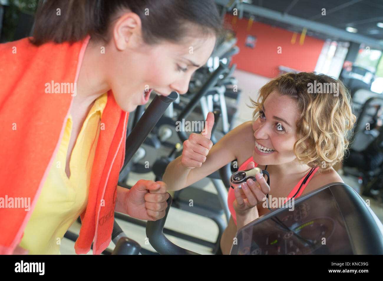 personal trainer congratulating young woman Stock Photo - Alamy