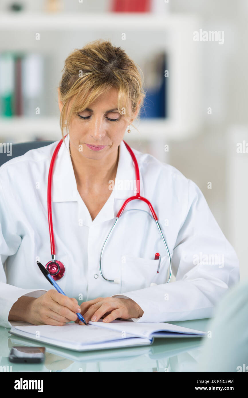 female doctor at her office writing something into her agenda Stock ...