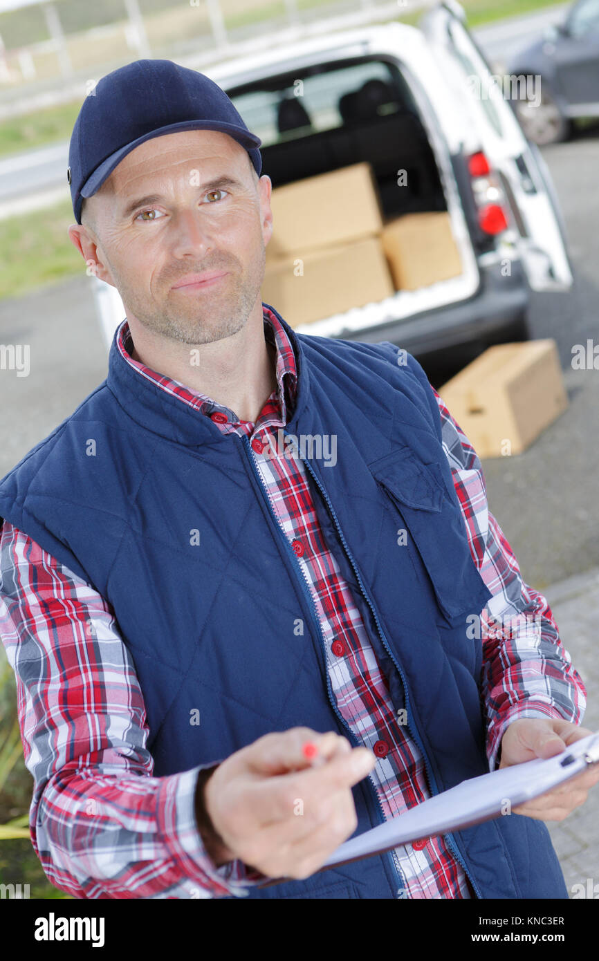delivery man asking to sign document Stock Photo - Alamy